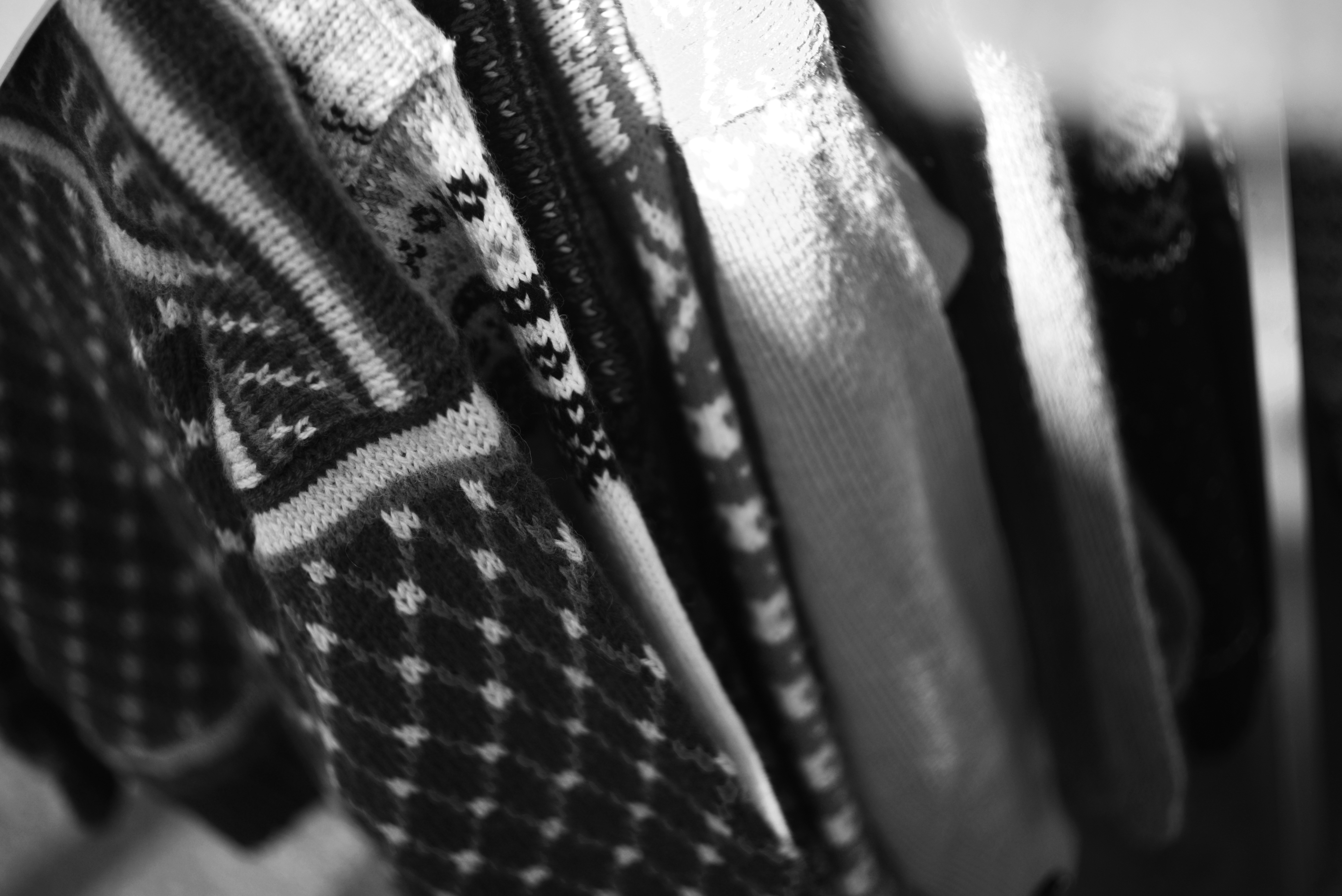 Close-knit Wardrobe: A monochrome selection of textured knits on a rack