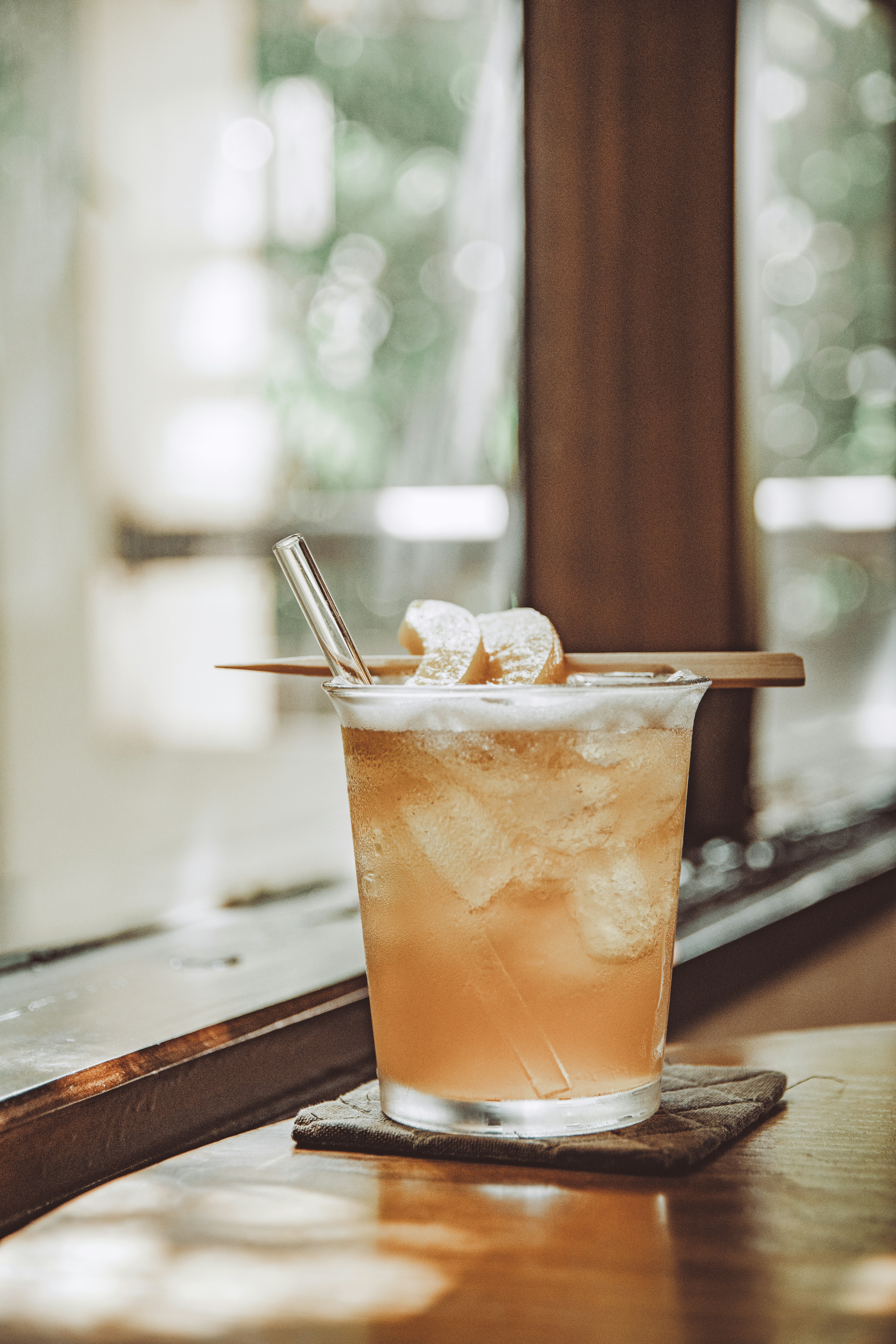 Gilded Ice: A Citrus-Top Cocktail Resting on a Wooden Bar