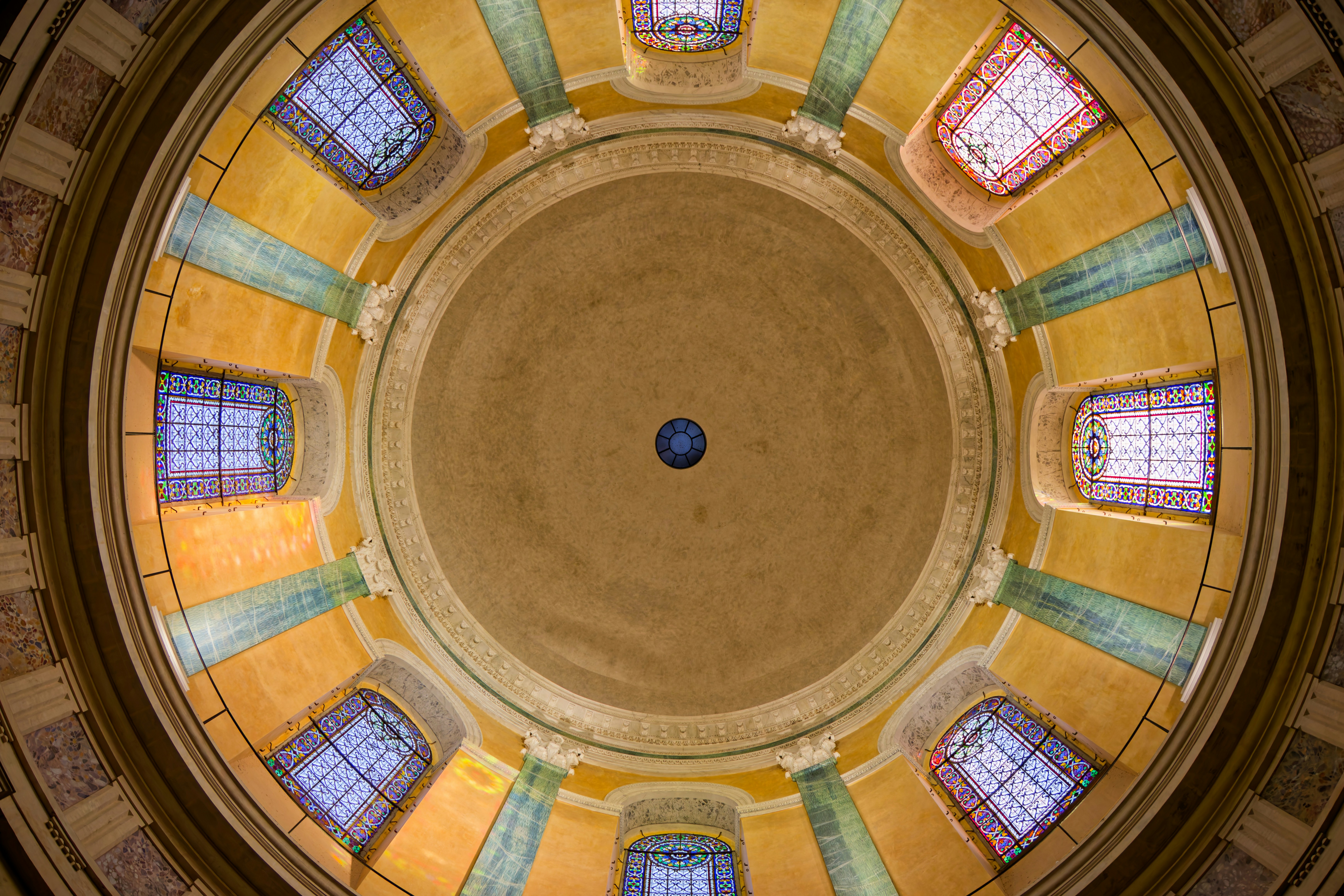 Ornate dome interior with windows and colorful striped patterns.