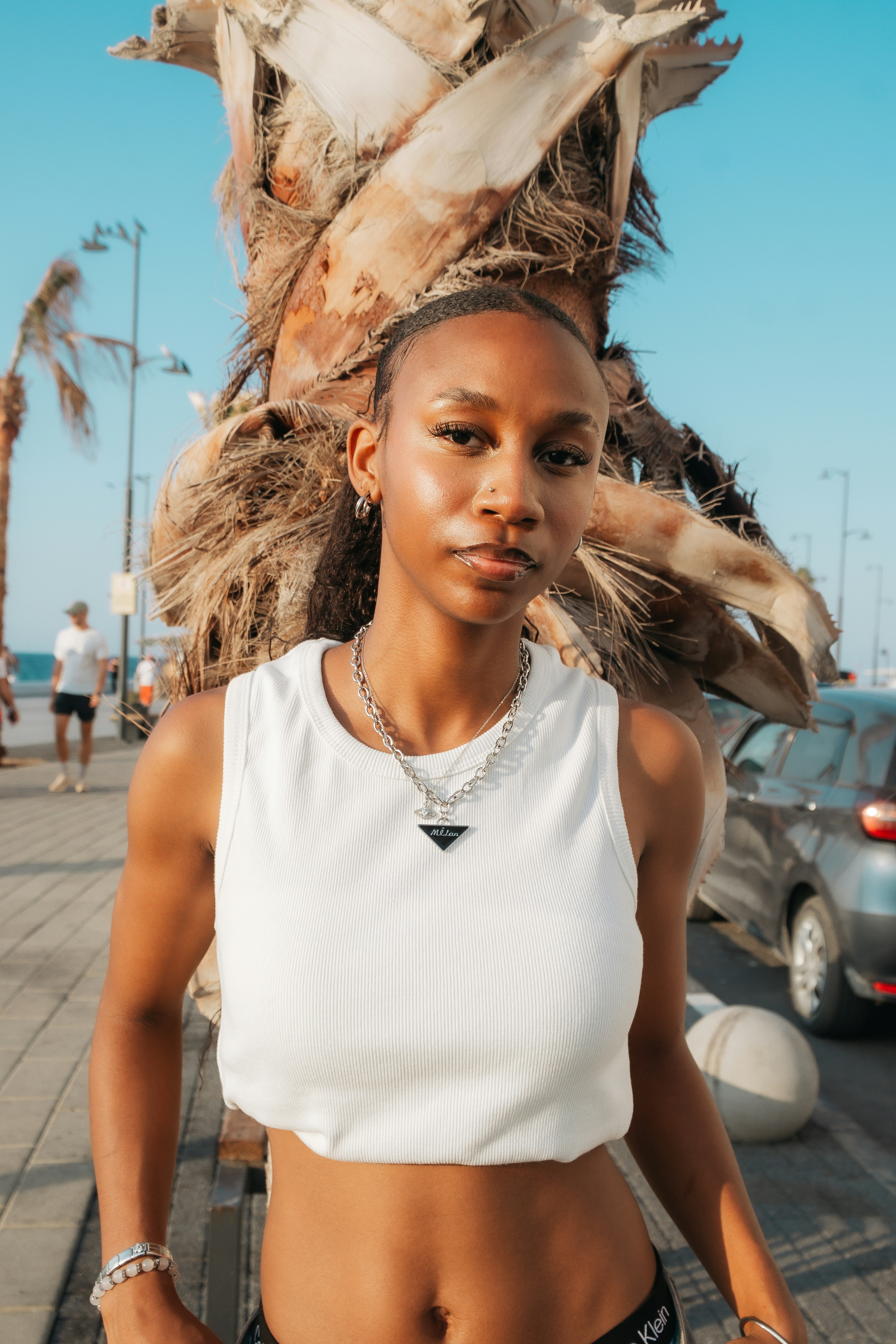 Sunlit Confidence: A Portrait Under Palms by the Sea