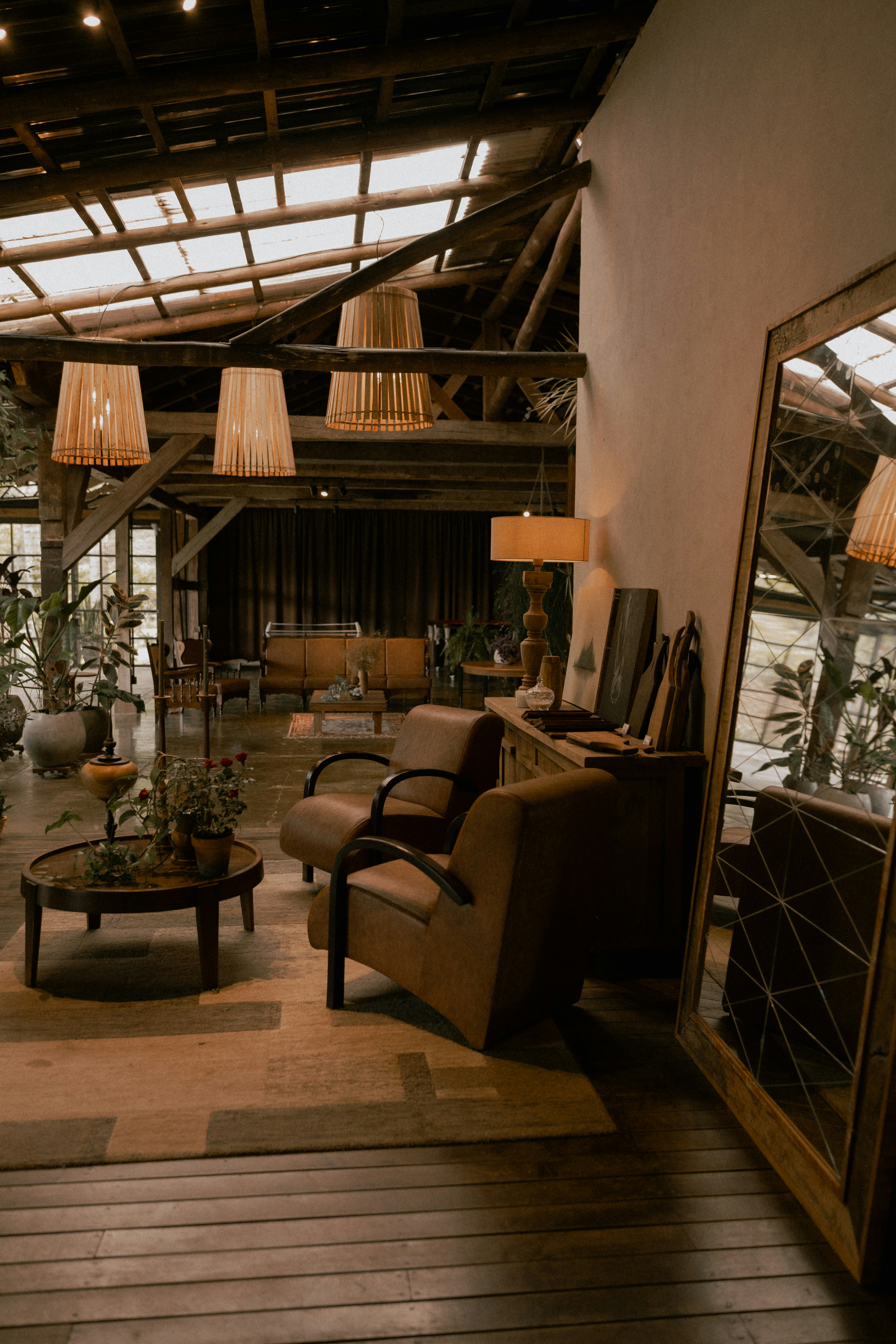 Warm Corner of a Rustic Lounge: Sofas, Plants, and Tilted Mirrors