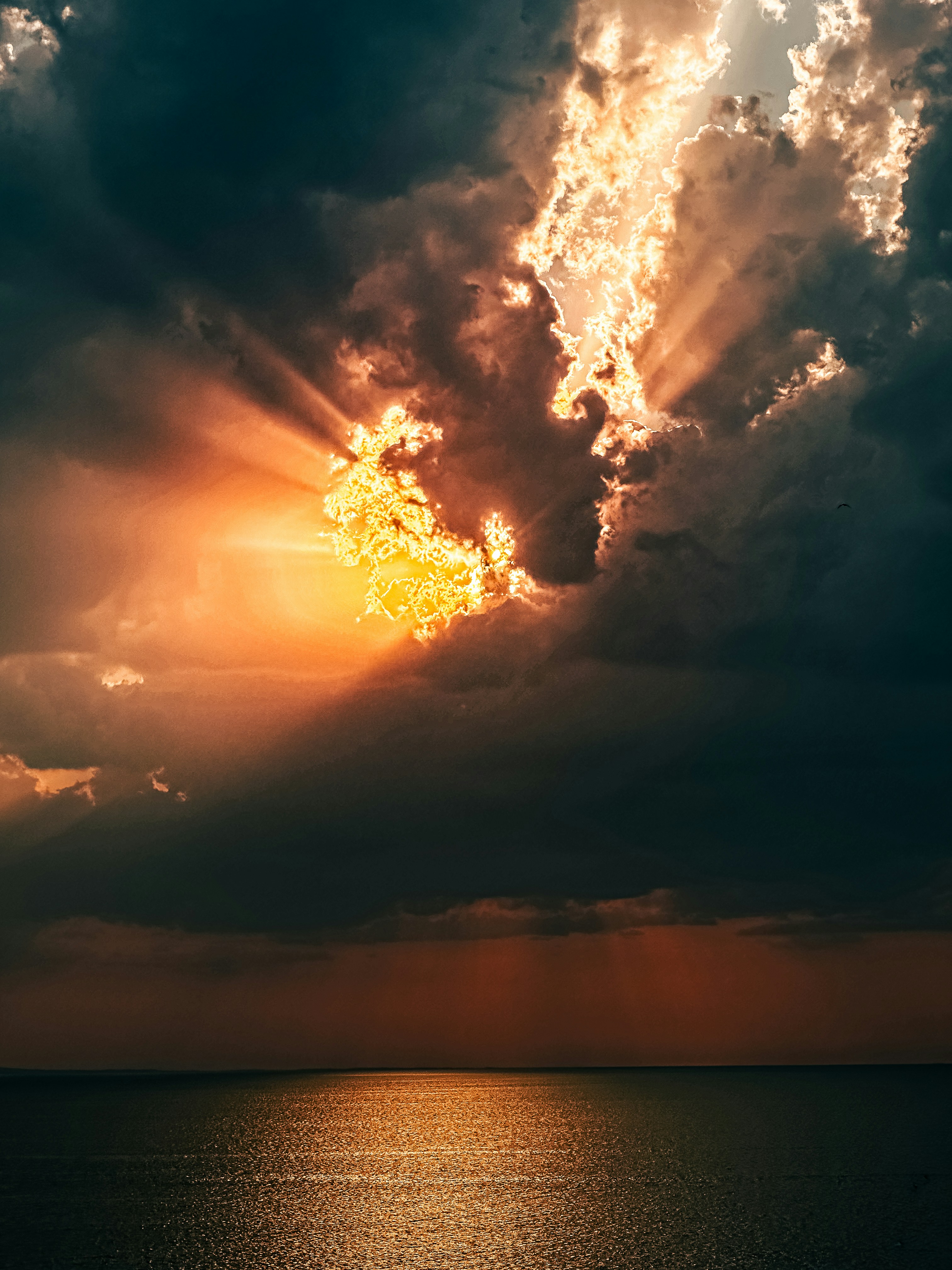 Sunburst Through Break in Clouds Over Silent Sea