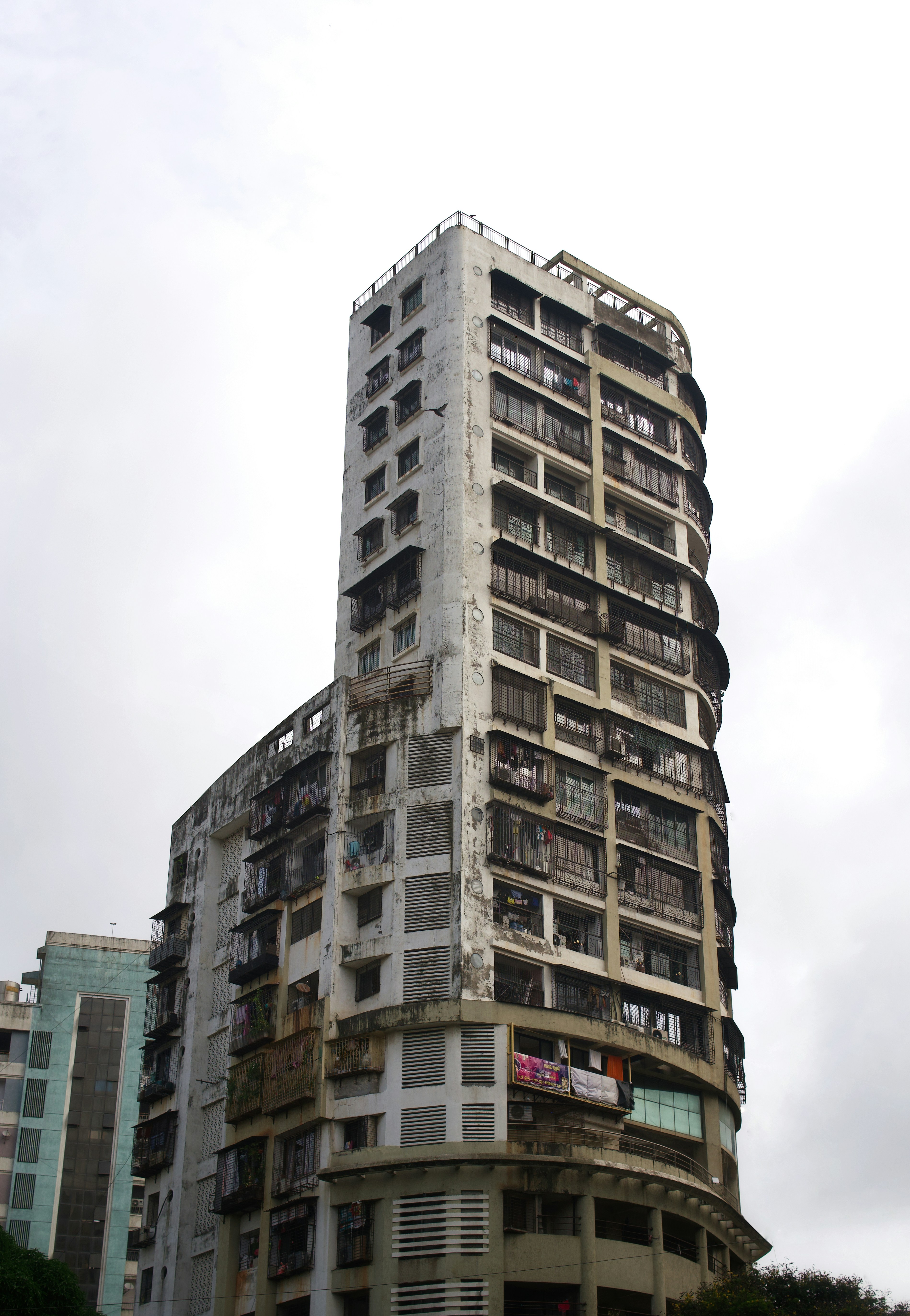 Curved Concrete: A Worn Urban Tower Reaches Skyward