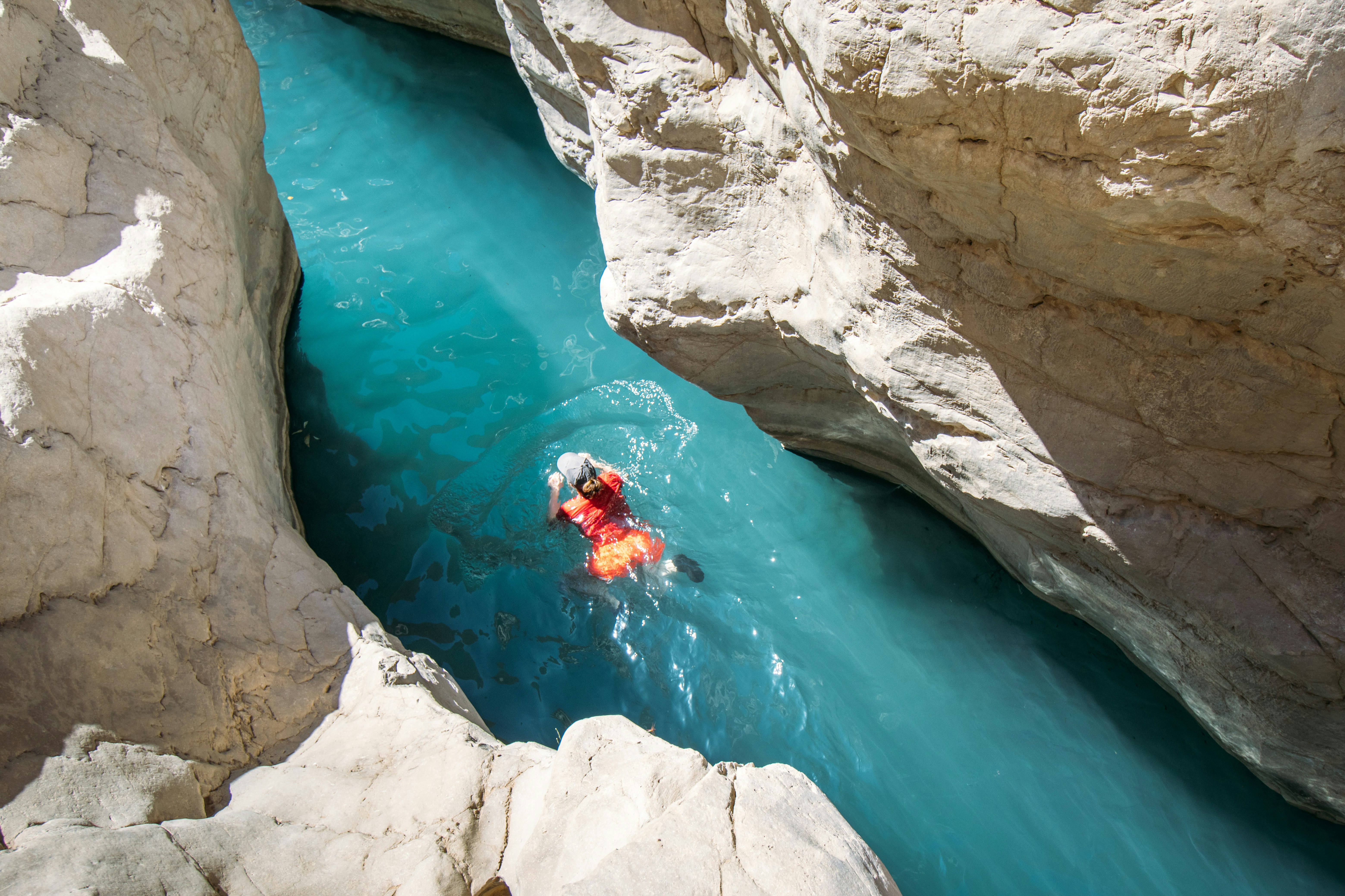 Azure Gorge: A lone swimmer carved through a narrow canyon