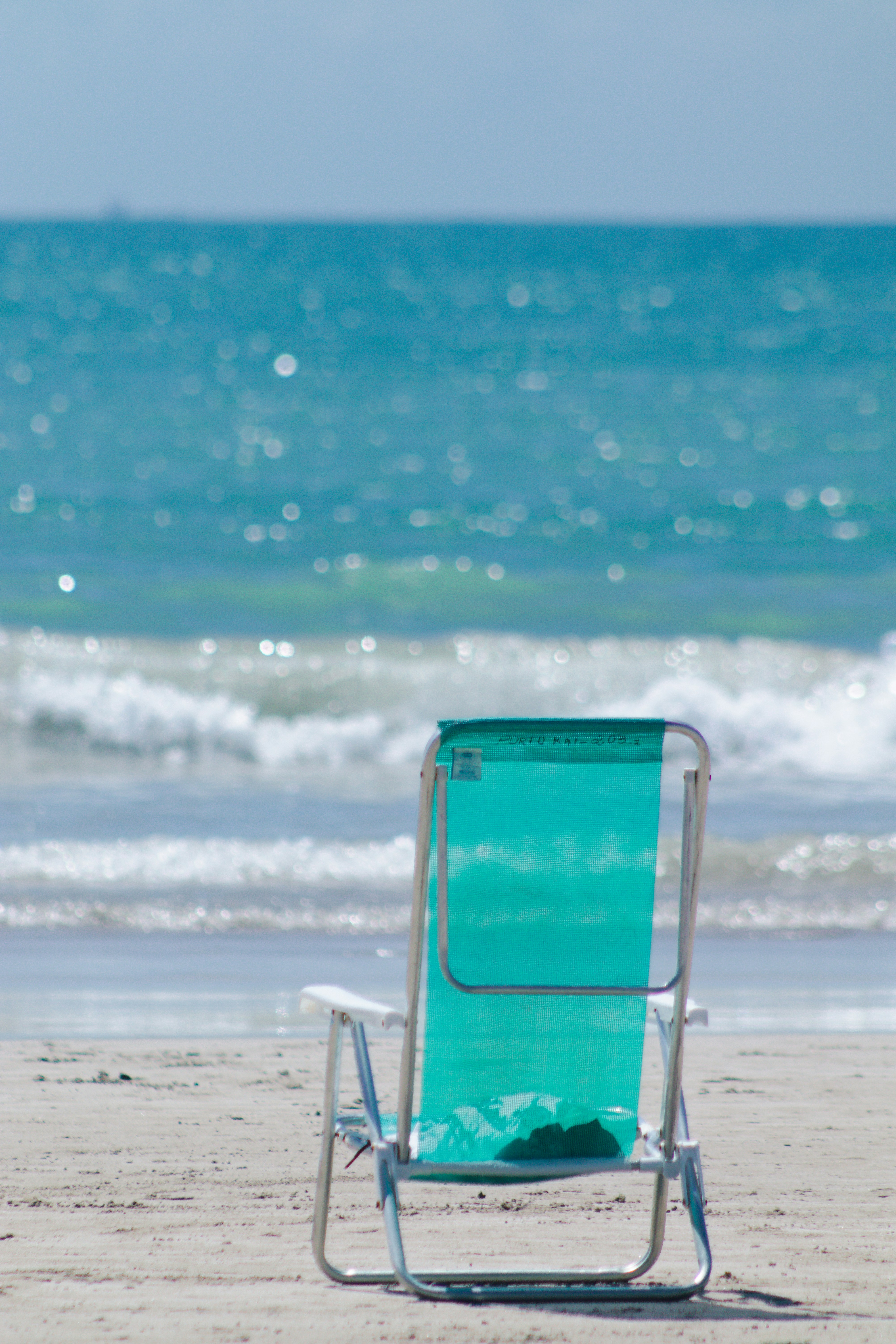 Teal Beach Chair in Focus: A Quiet Seaside Moment