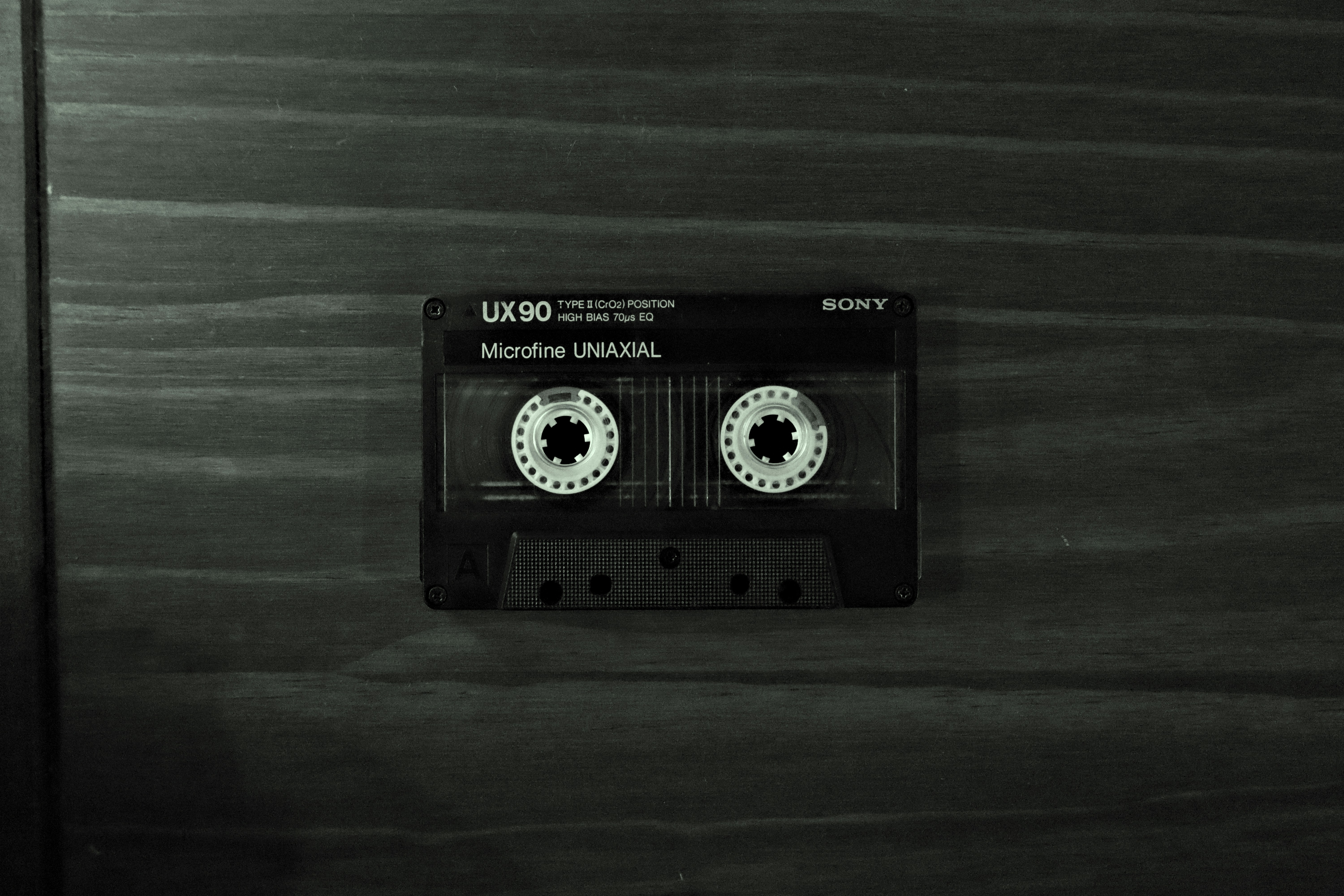 Muted Echo: A Silent Sony UX90 Cassette on Dark Wood