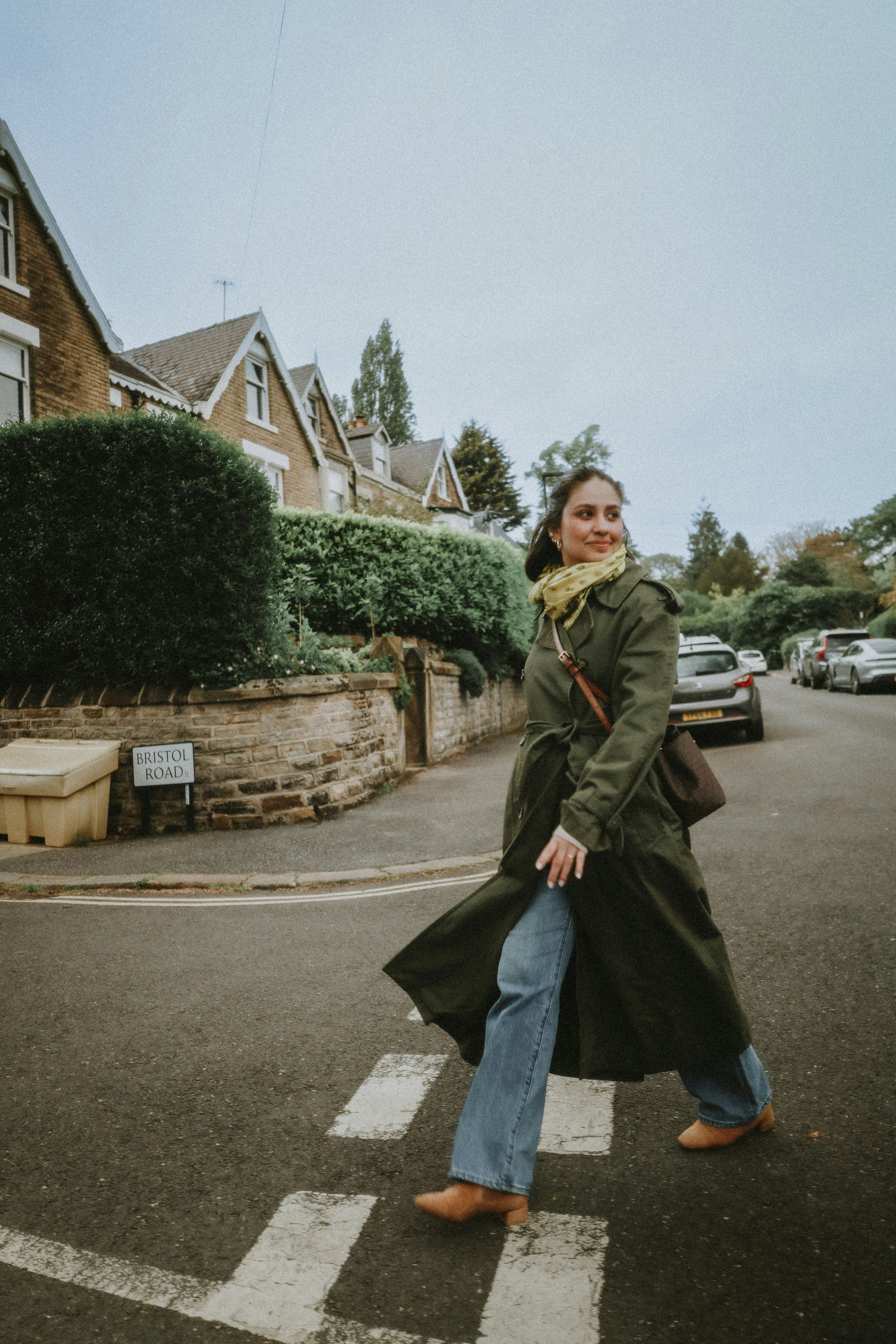 Crosswalk Confidence: a woman strides through a quiet suburban street