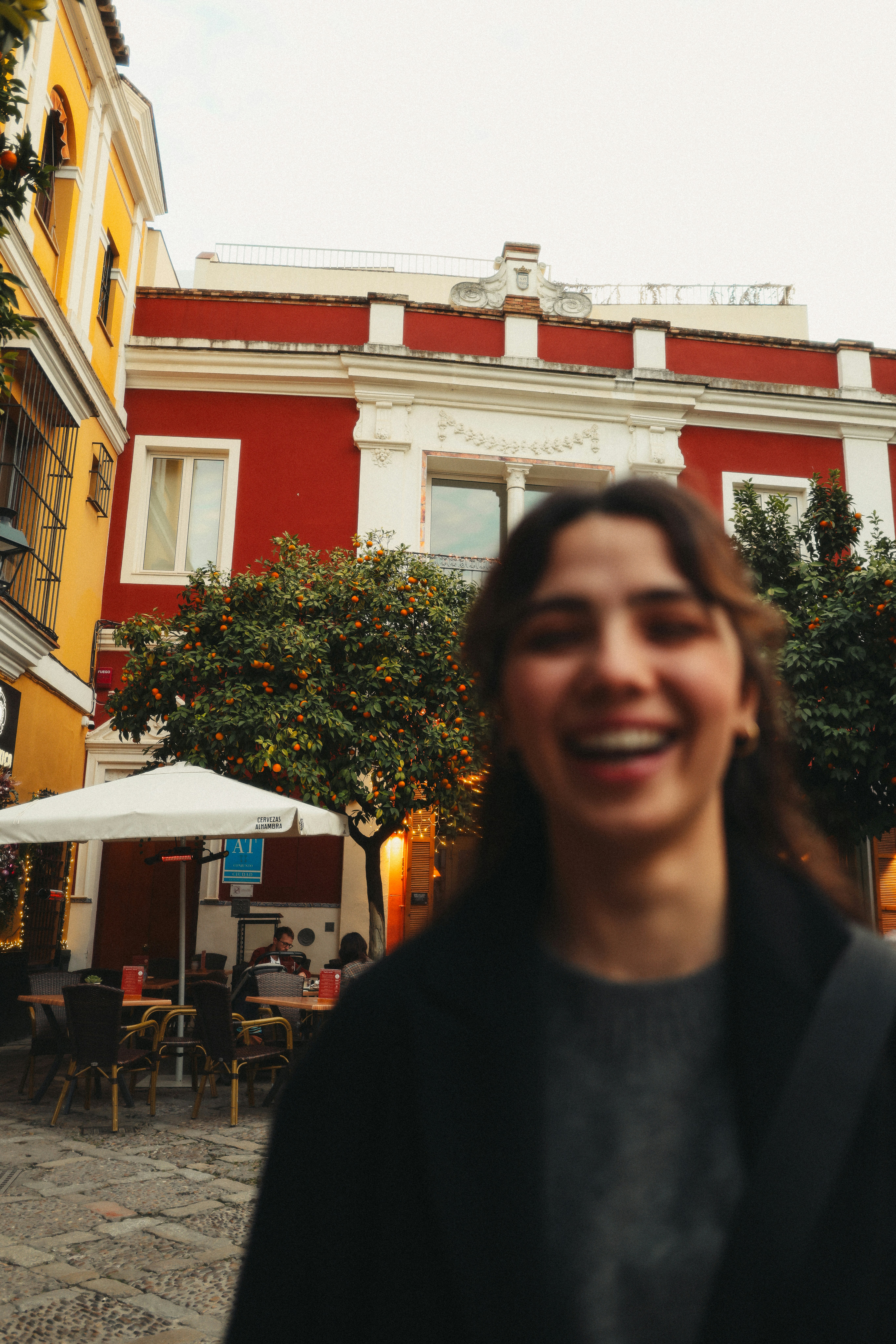 Laughing in a sunlit plaza: a candid moment before the blur