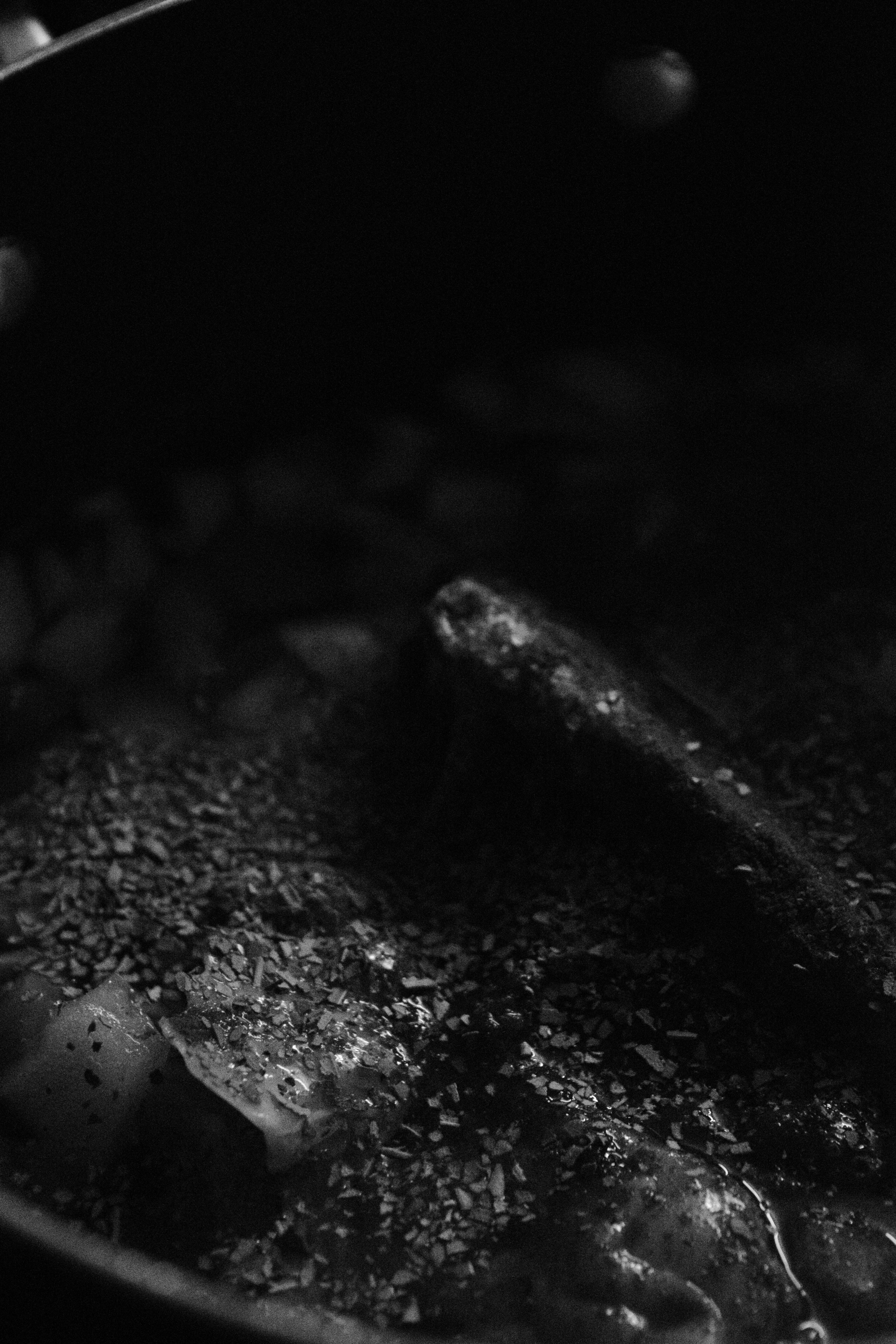 Moonlit Soot: A Charred Pebble Under Lava-dark Surface
