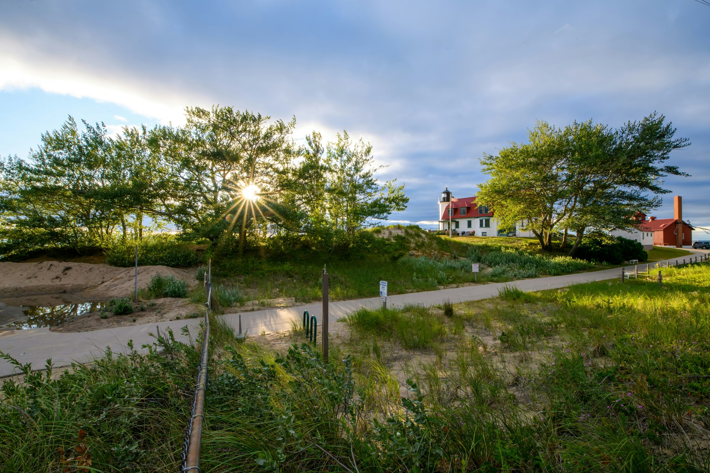 Sunlit Farmhouse Arc: A Quiet Coastal Meadow at Dusk