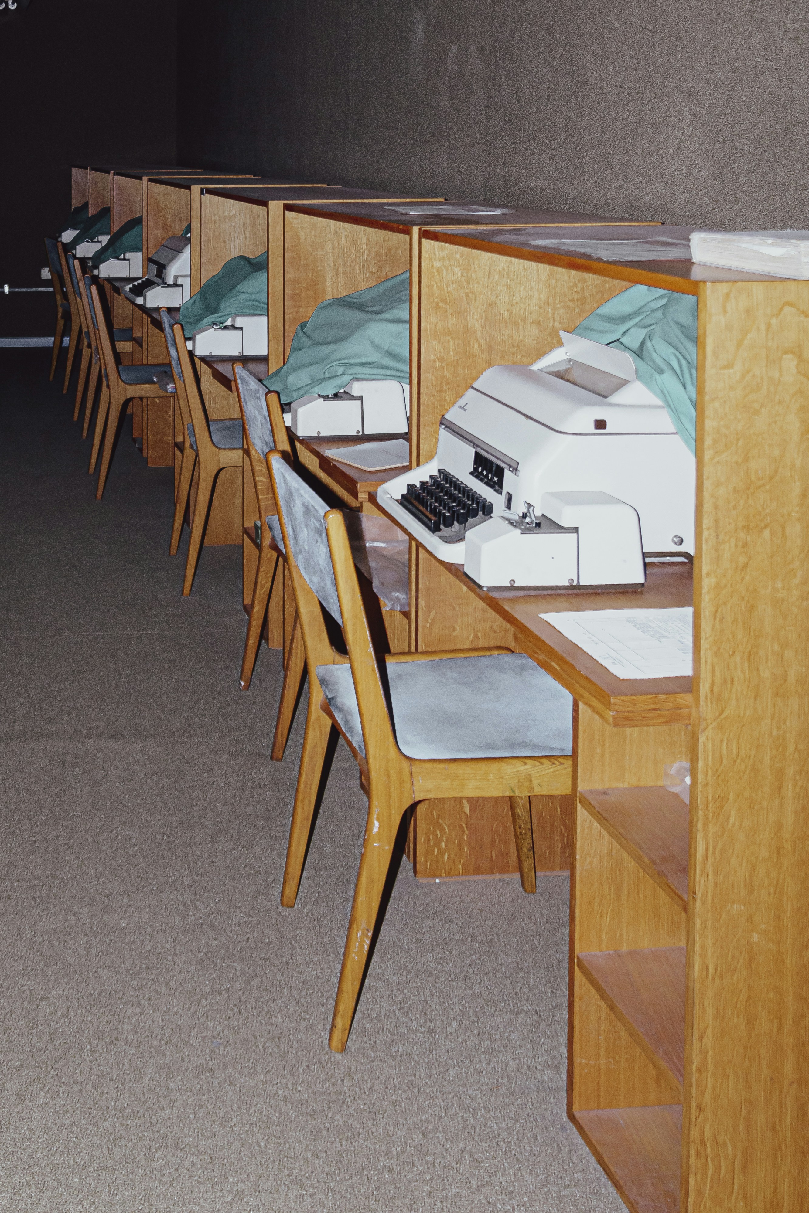 Row of vintage offices: silent typewriters under dim office lights
