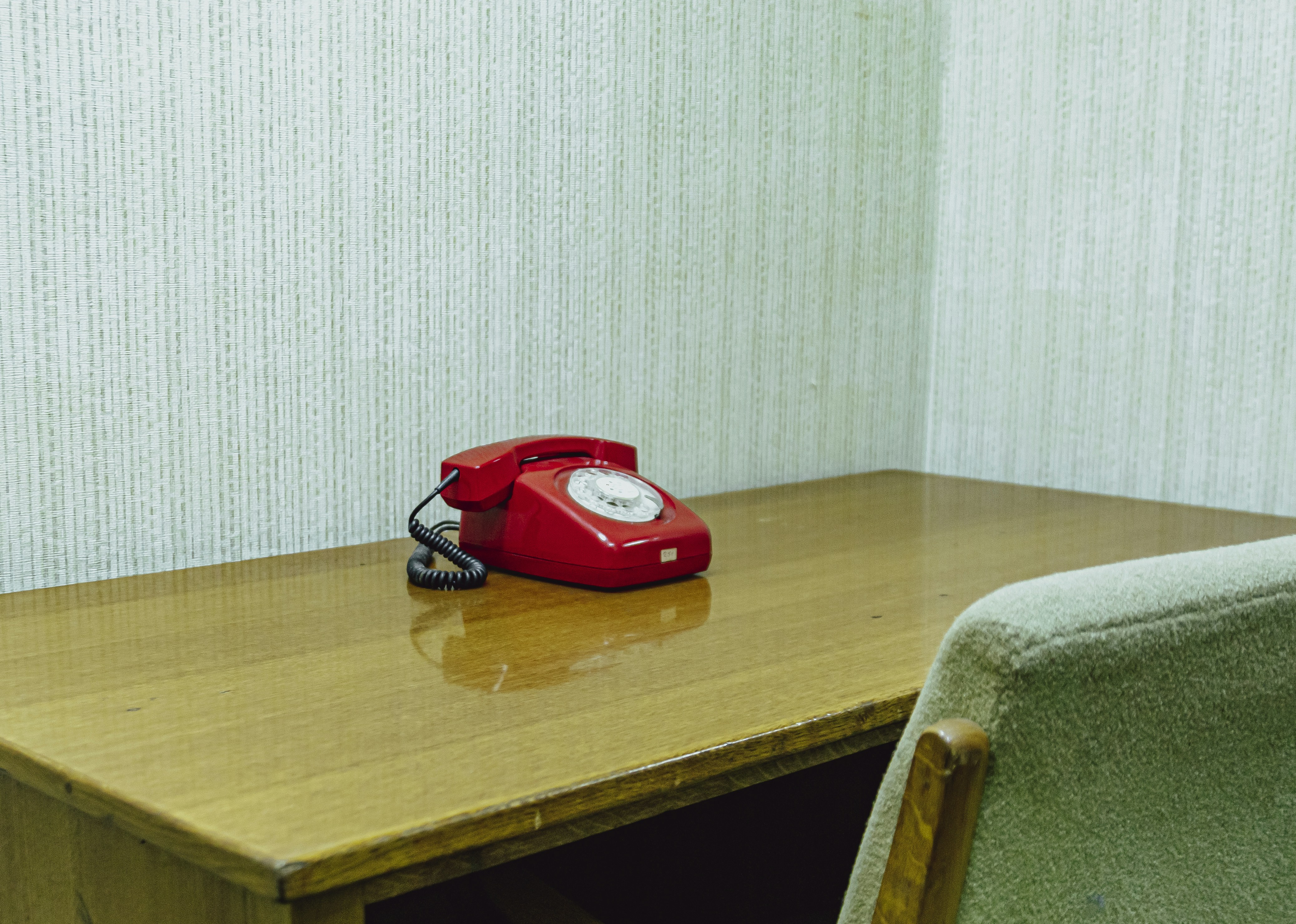 Red Rotary: A Vintage Desk Phone Anchors a Quiet Office Scene