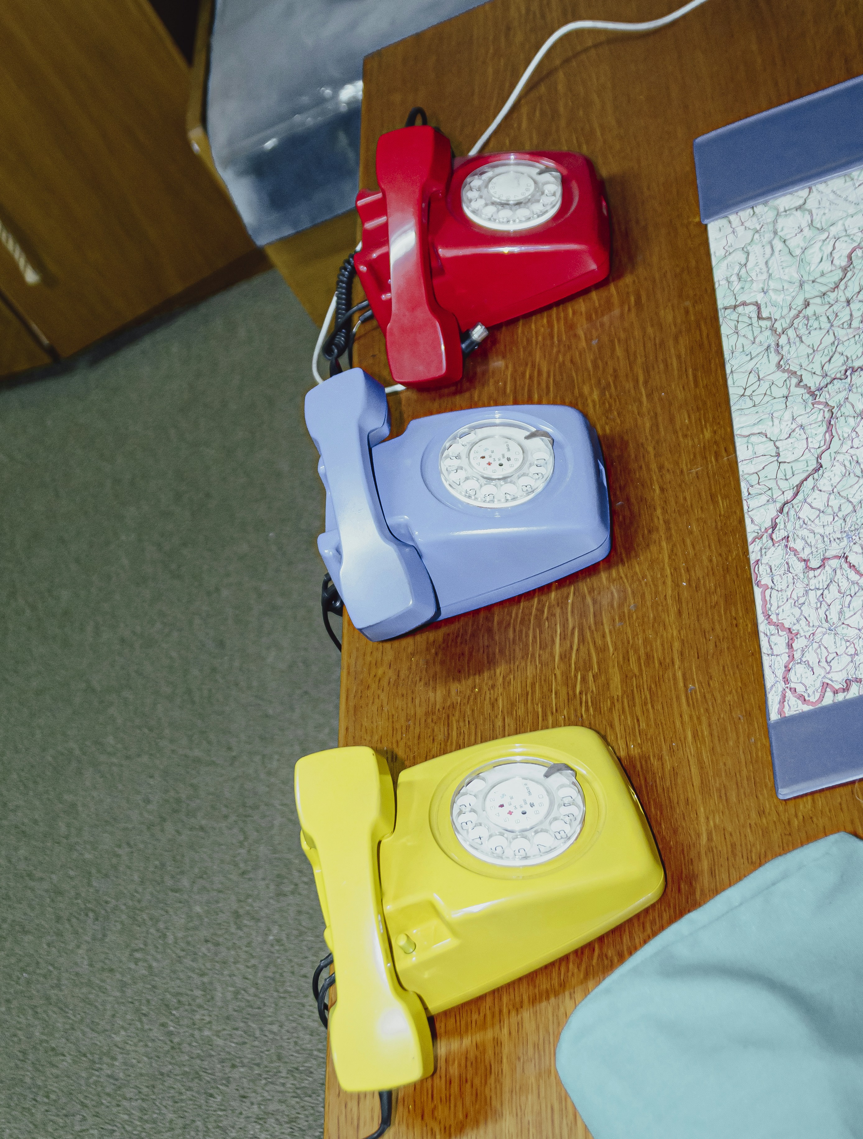 Three Colored Telephones on a Desk: A Retro Office Scene