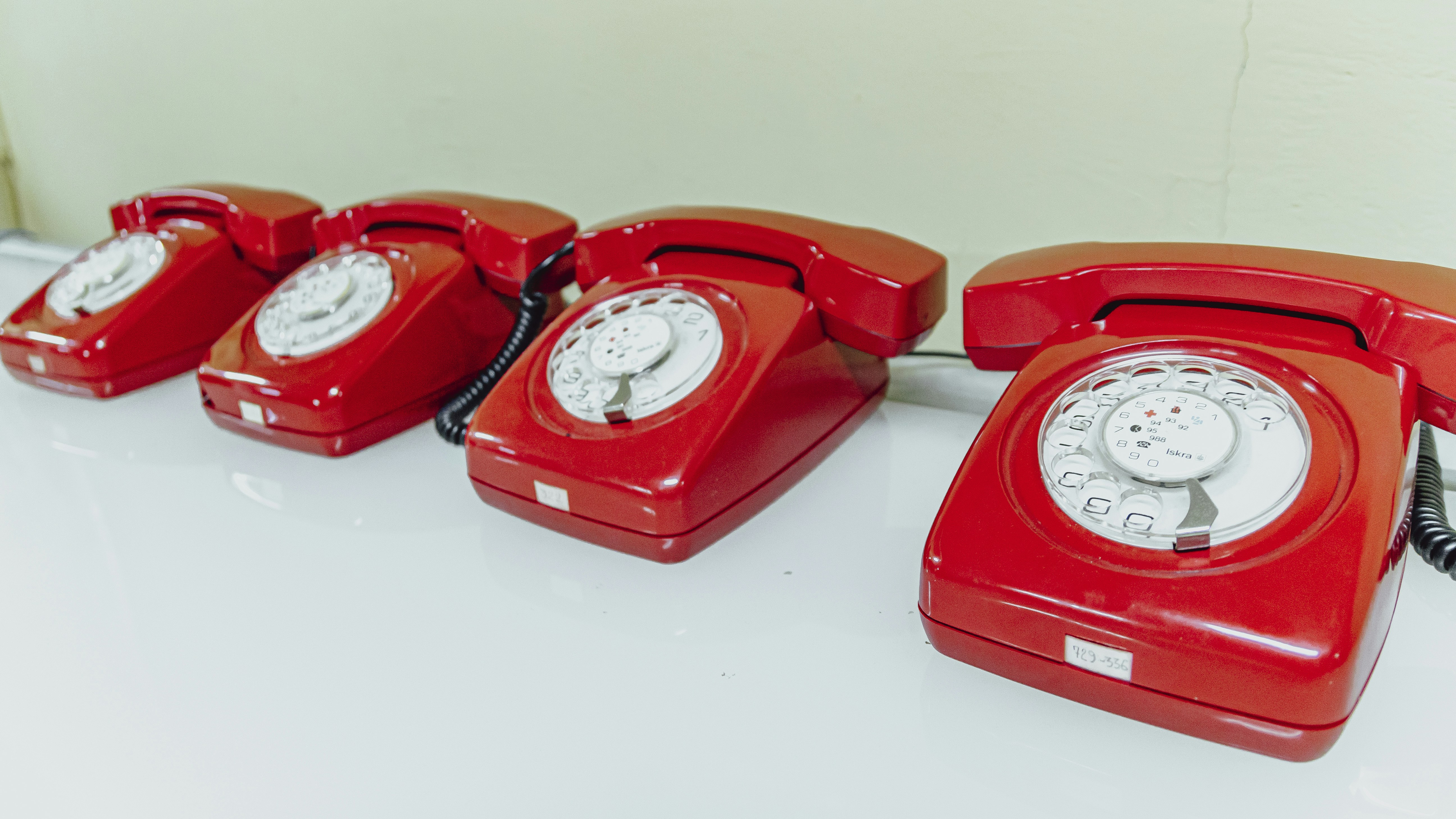 Red Lines of Connection: Vintage Rotary Telephones in a Row