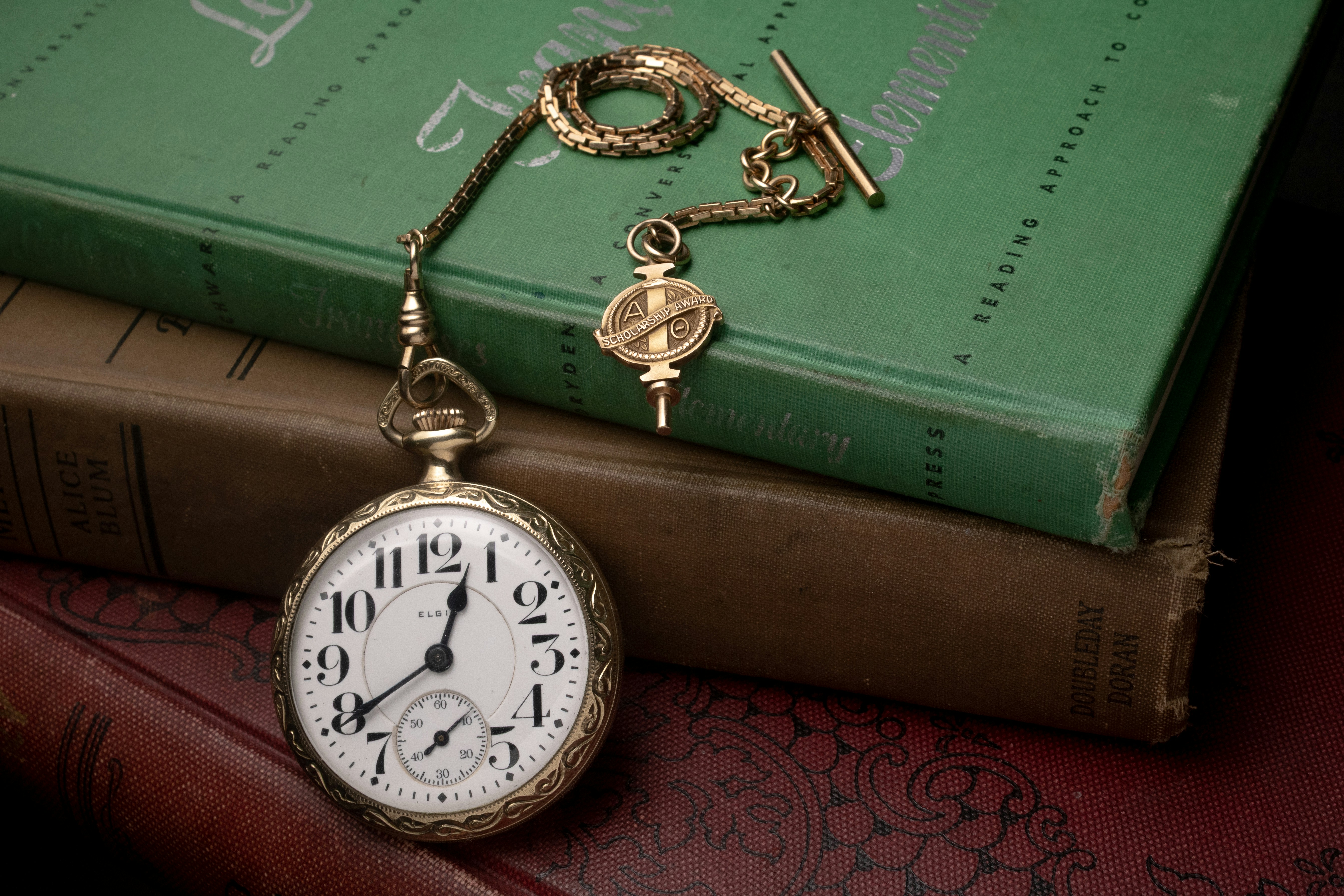 Timekeeper's Quiet Ledge: A Pocket Watch Among Old Tomes