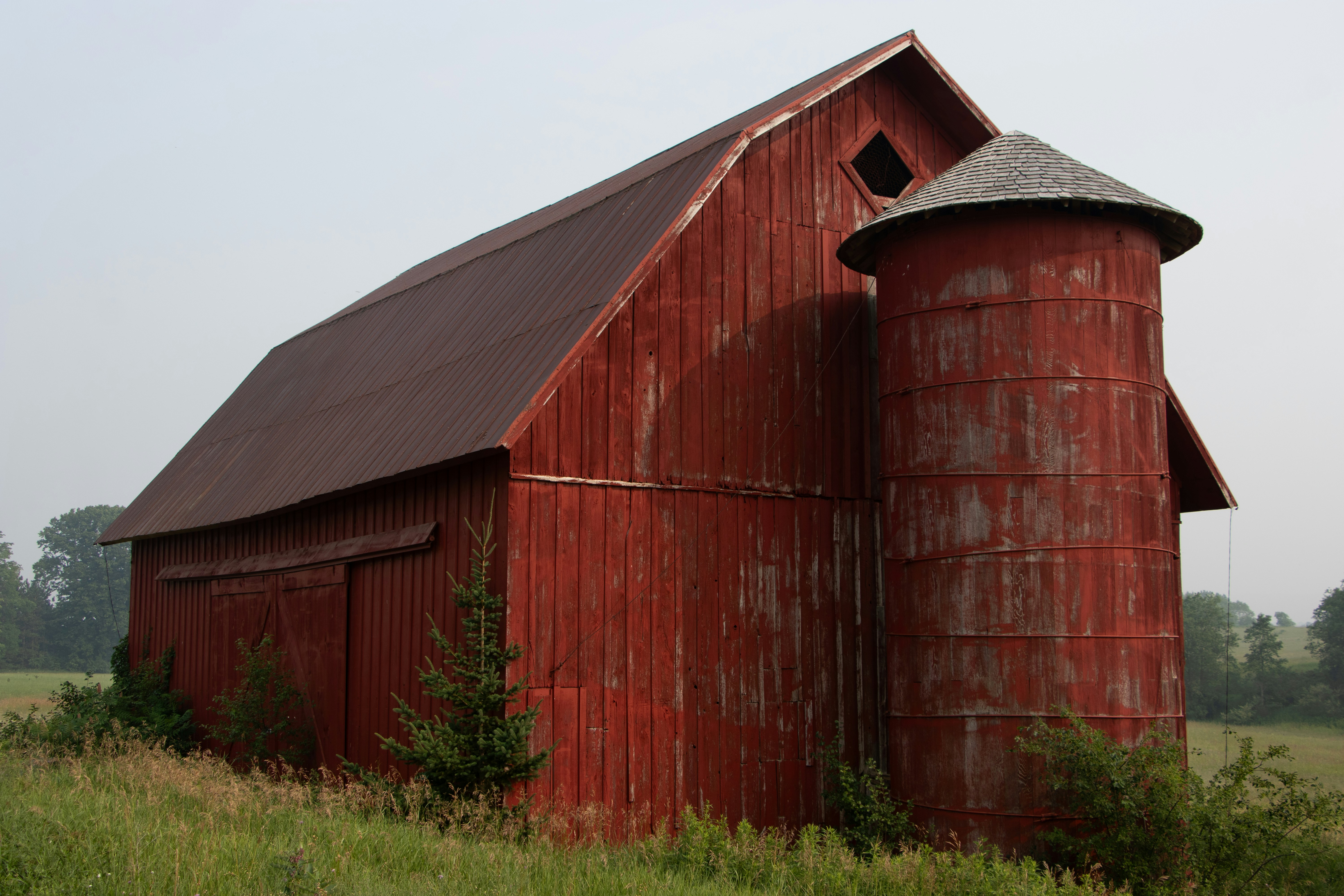 Red Barn and Silos in Open Field at Dusk