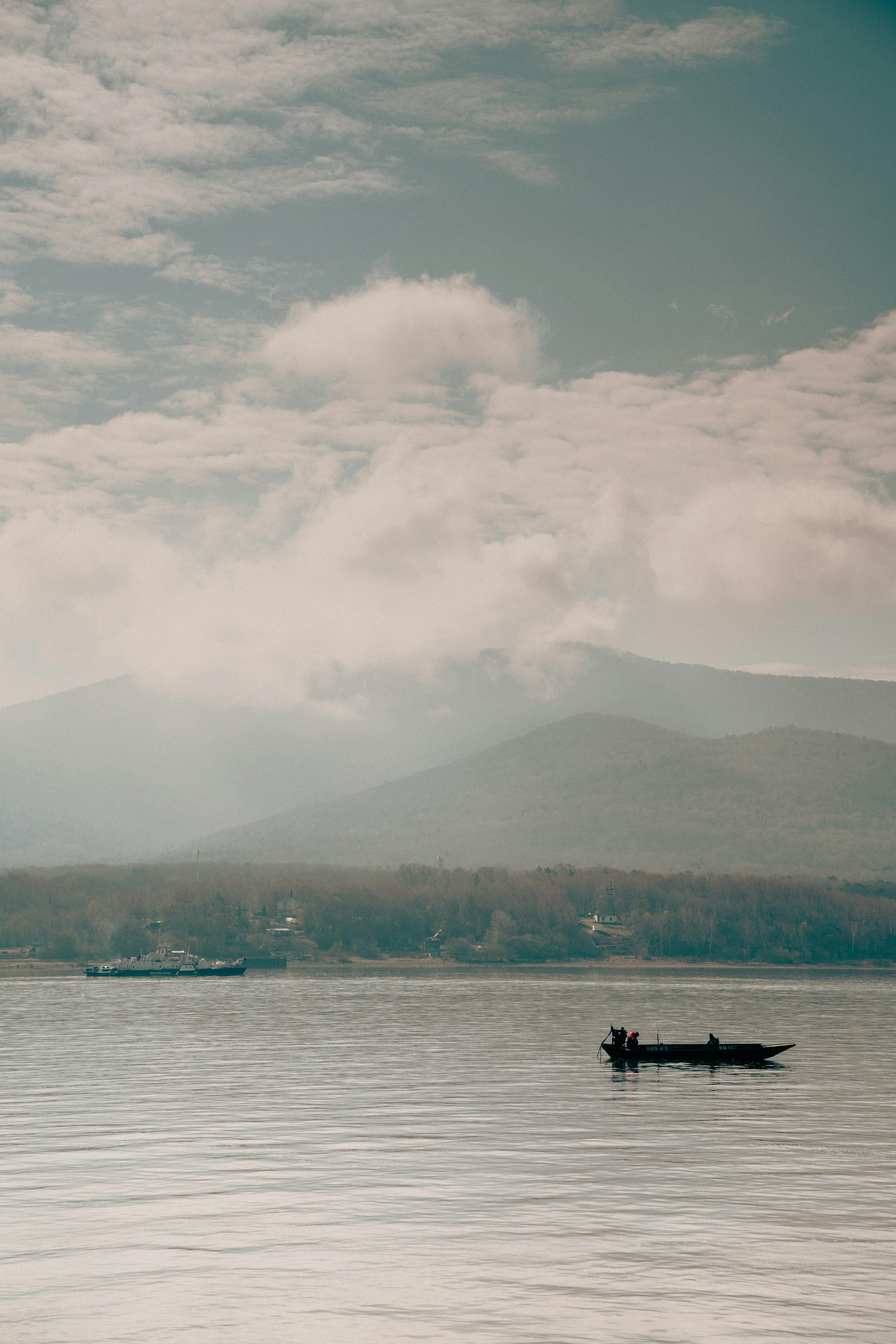 Quiet River, Mighty Clouds: A Distant Landscape Framed by Calm Waters