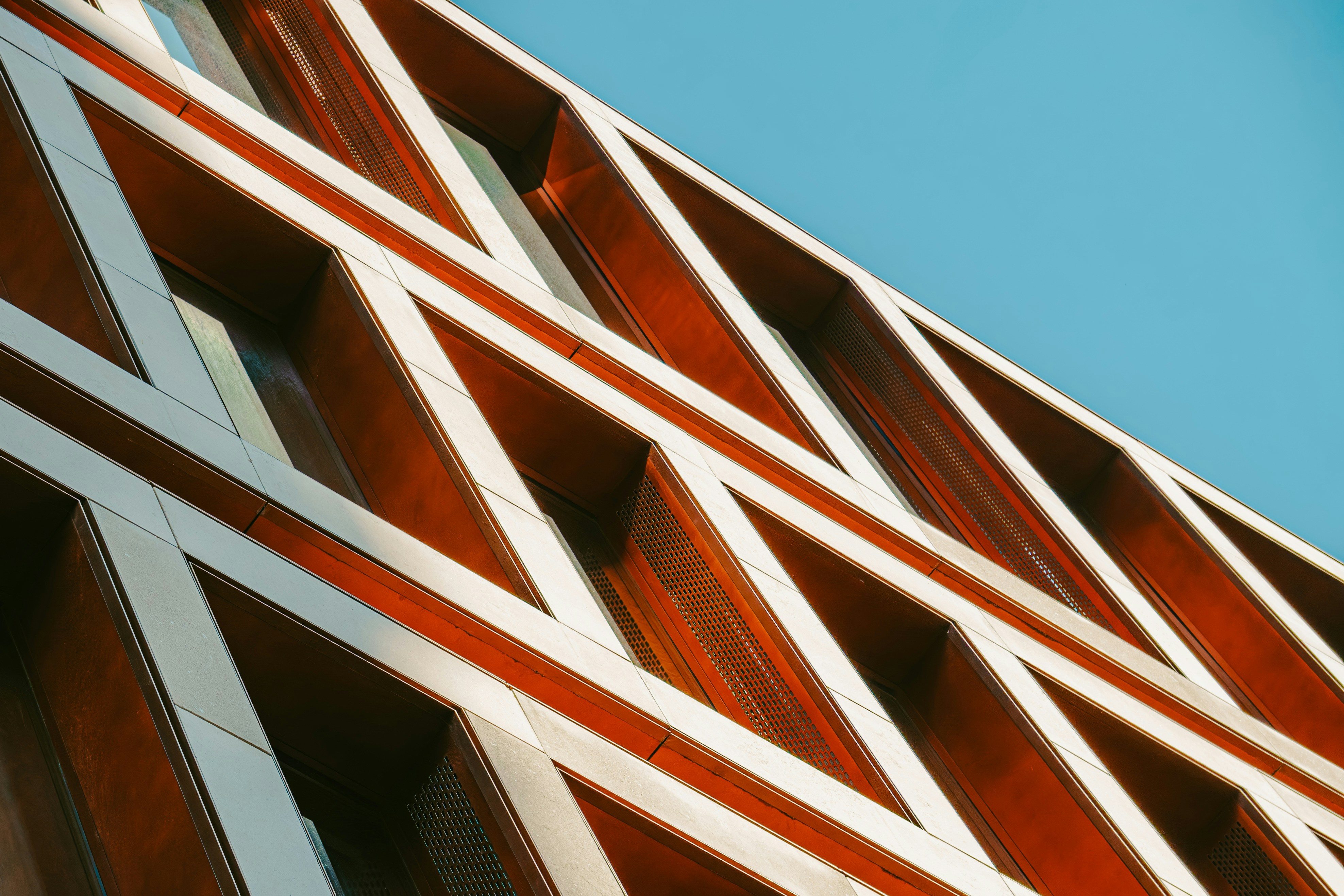 Diagonal Facade: Intersecting Angles of Red and Steel