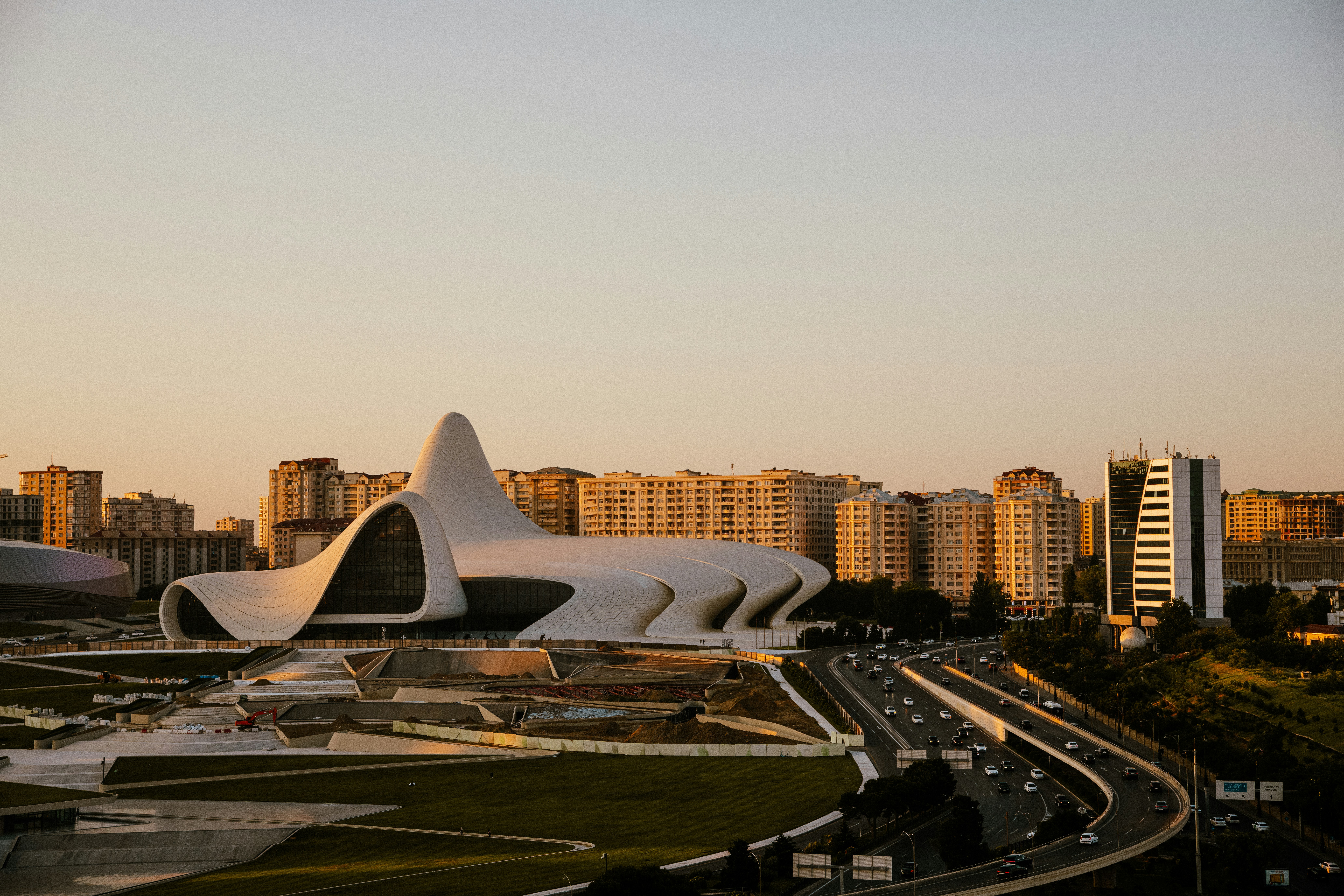 Fluid Architecture at Golden Hour: The Wavy Museum Silhouetted Against a Cityscape