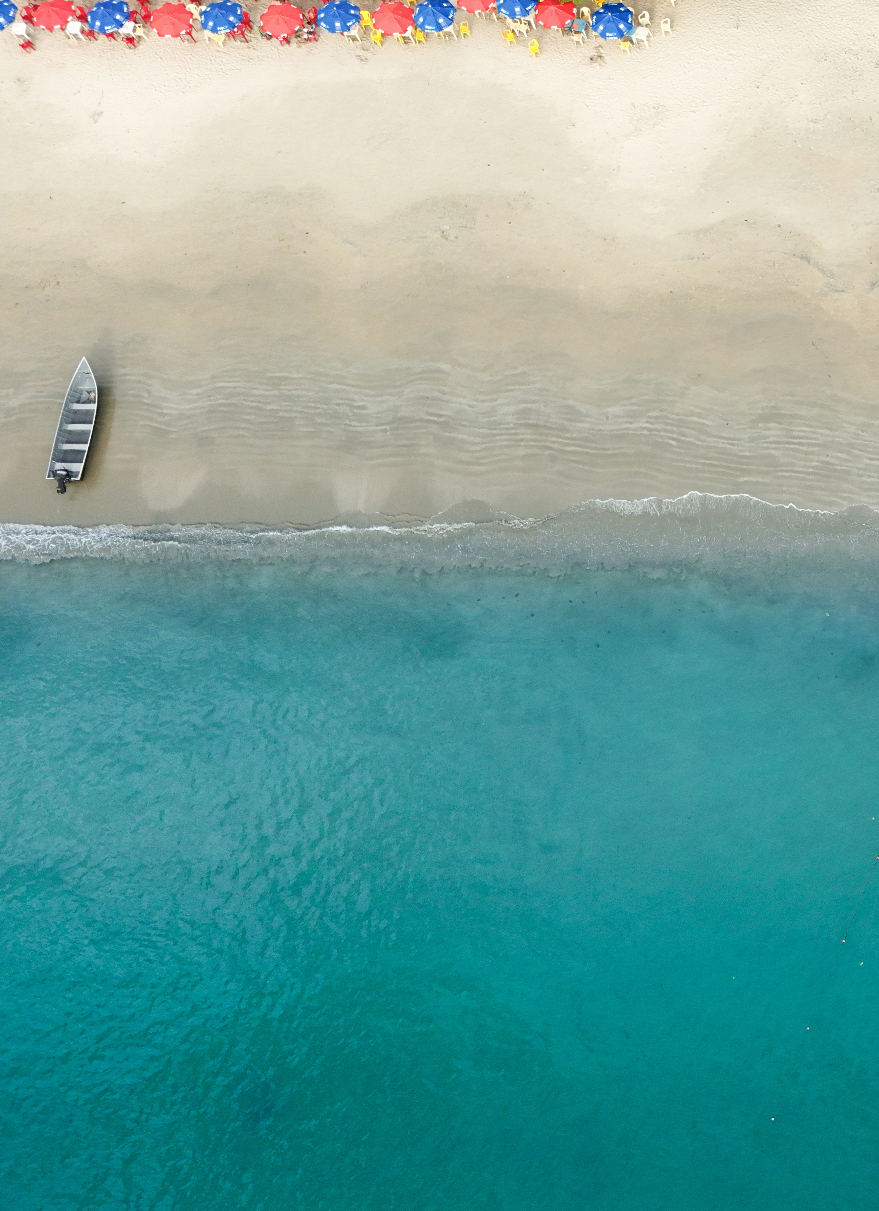 Sail and Shoreline: A Quiet Beach from Above