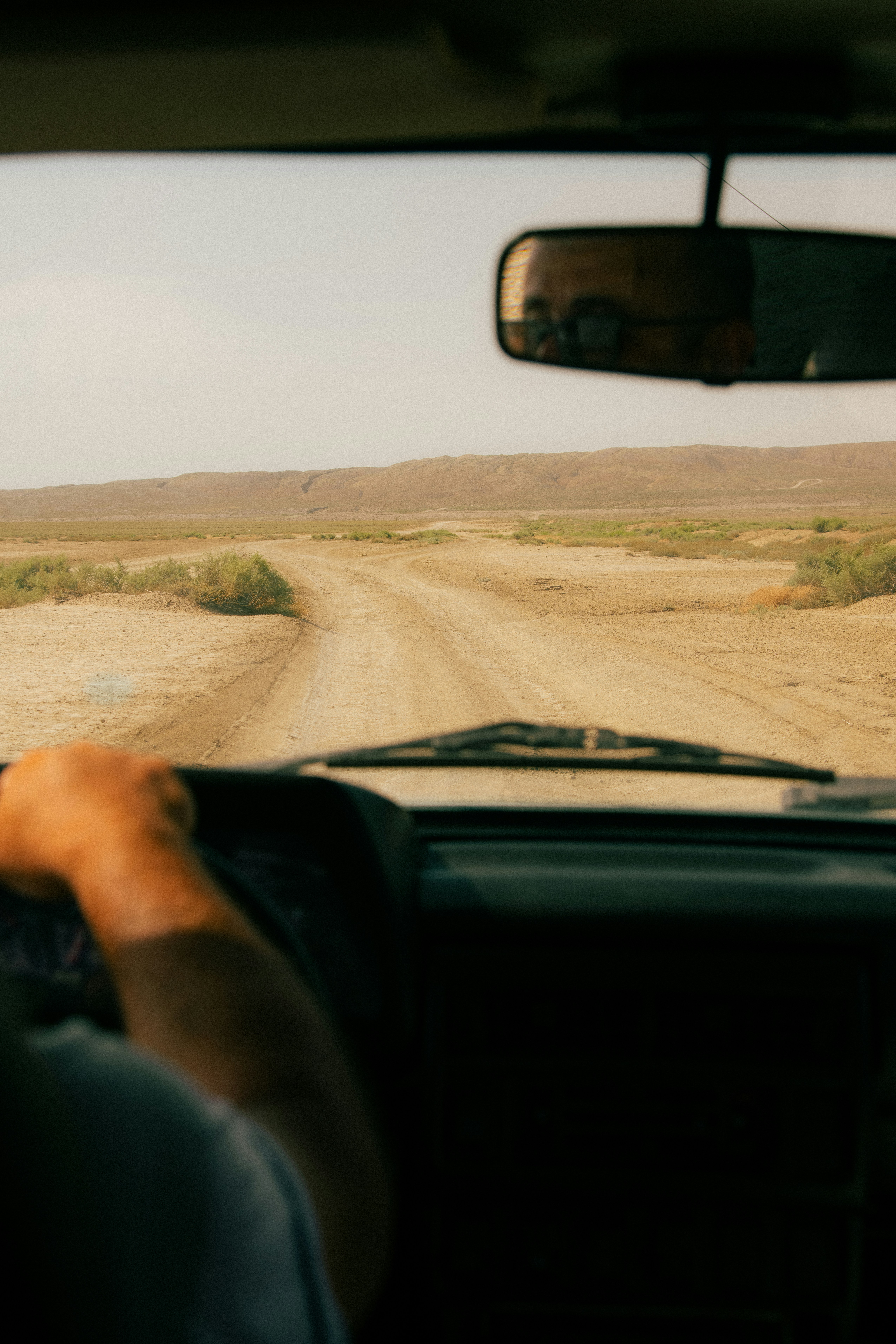 Front-Seat View: A Desert Road Unfolds Beneath the Driver’s Gaze