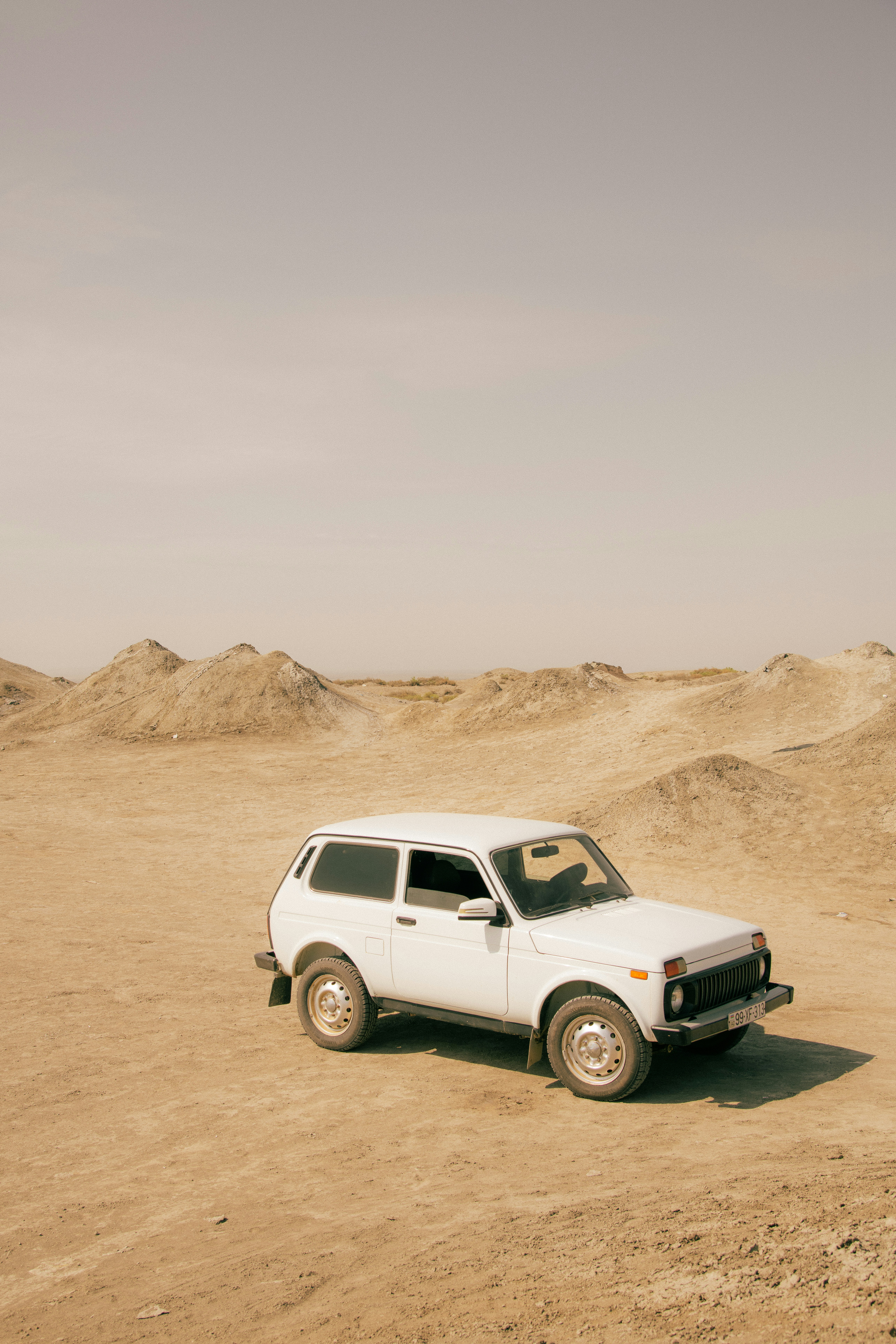 Desert Drive: A White Off-Road Vehicle Pauses Among Sand Dunes