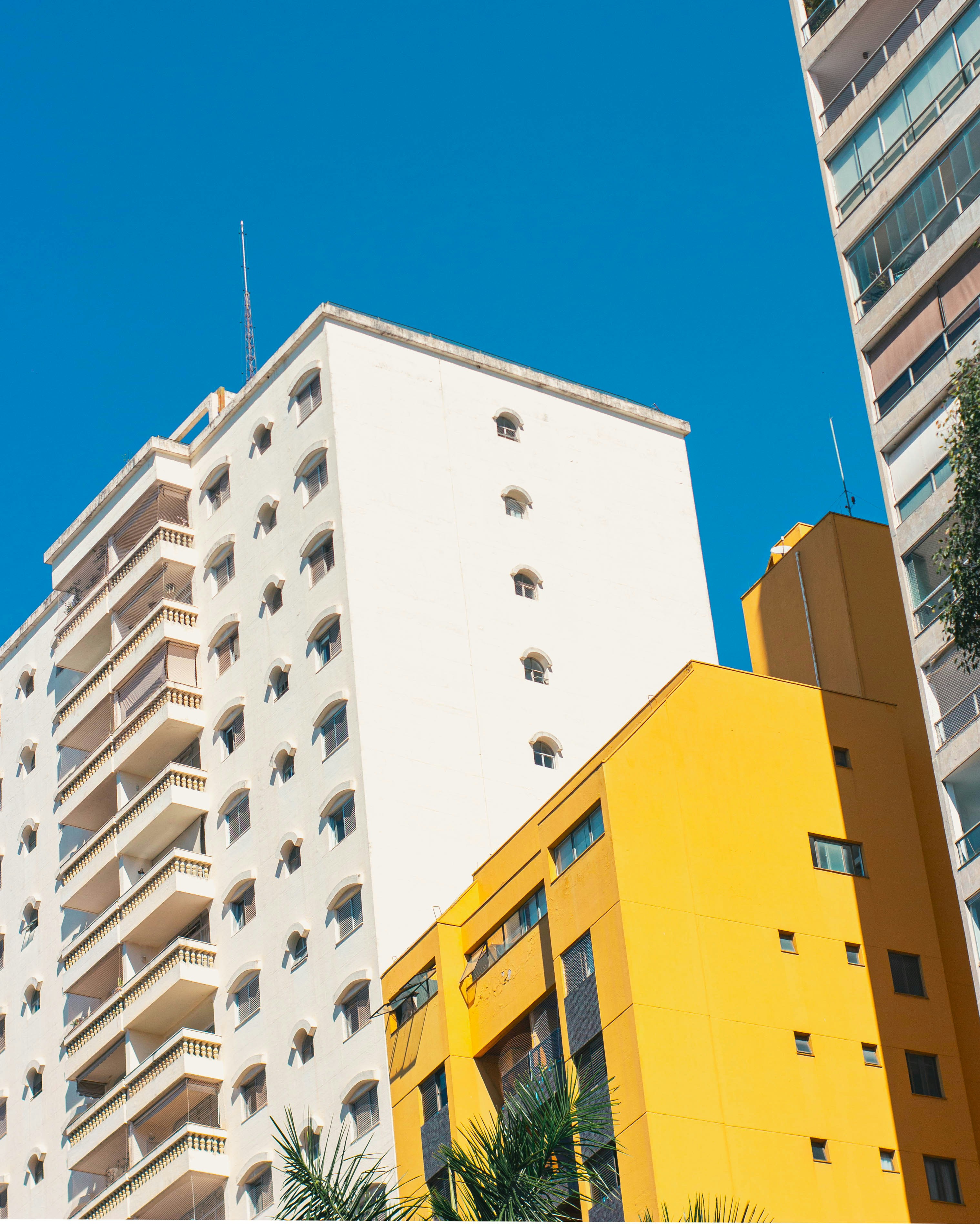 Bright City Face: A Bold Yellow Tower Against A Clear Blue Sky