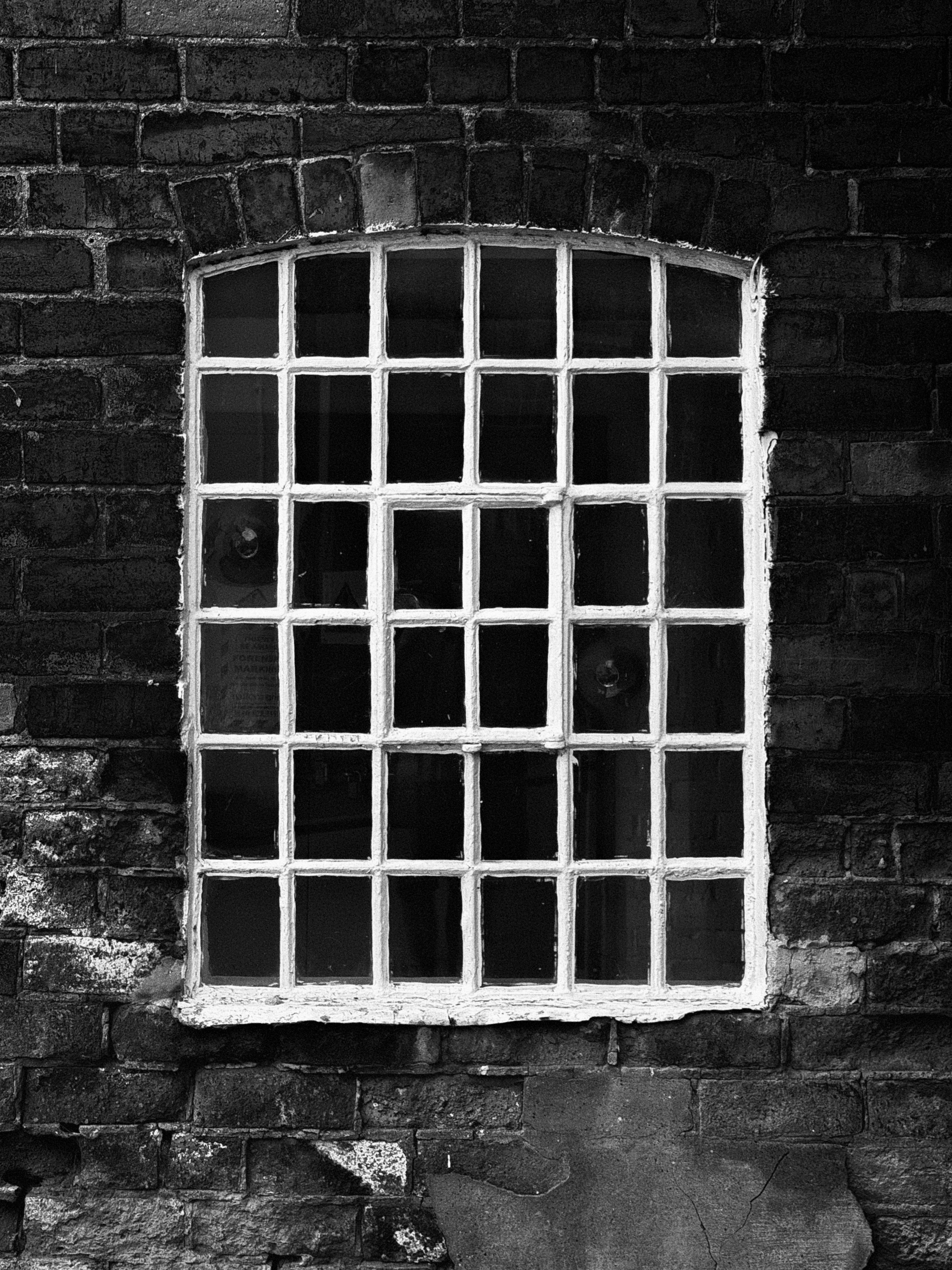 Gridded Window in Weathered Brick Wall