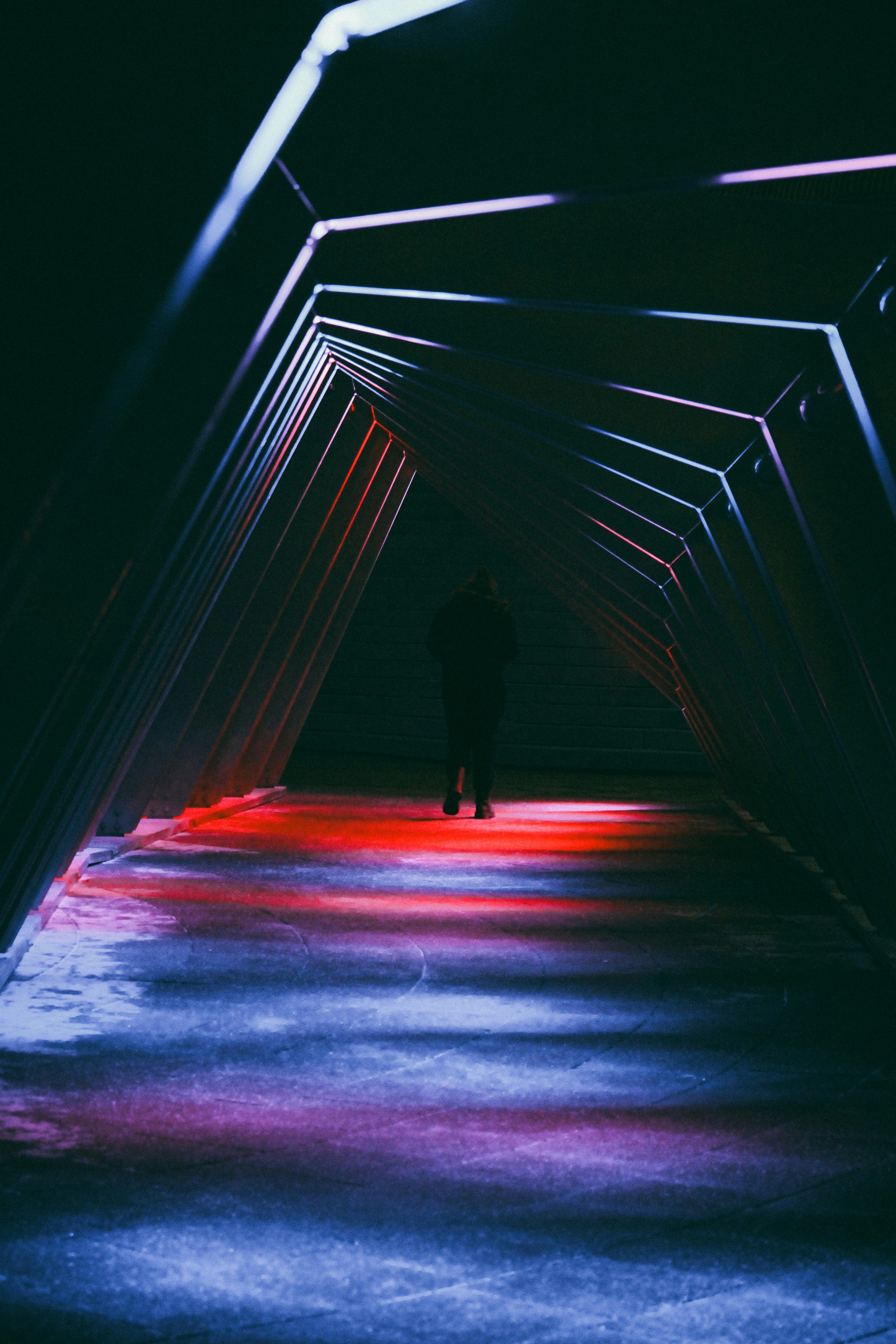 Neon Archway: A Silhouette Walks Toward the End