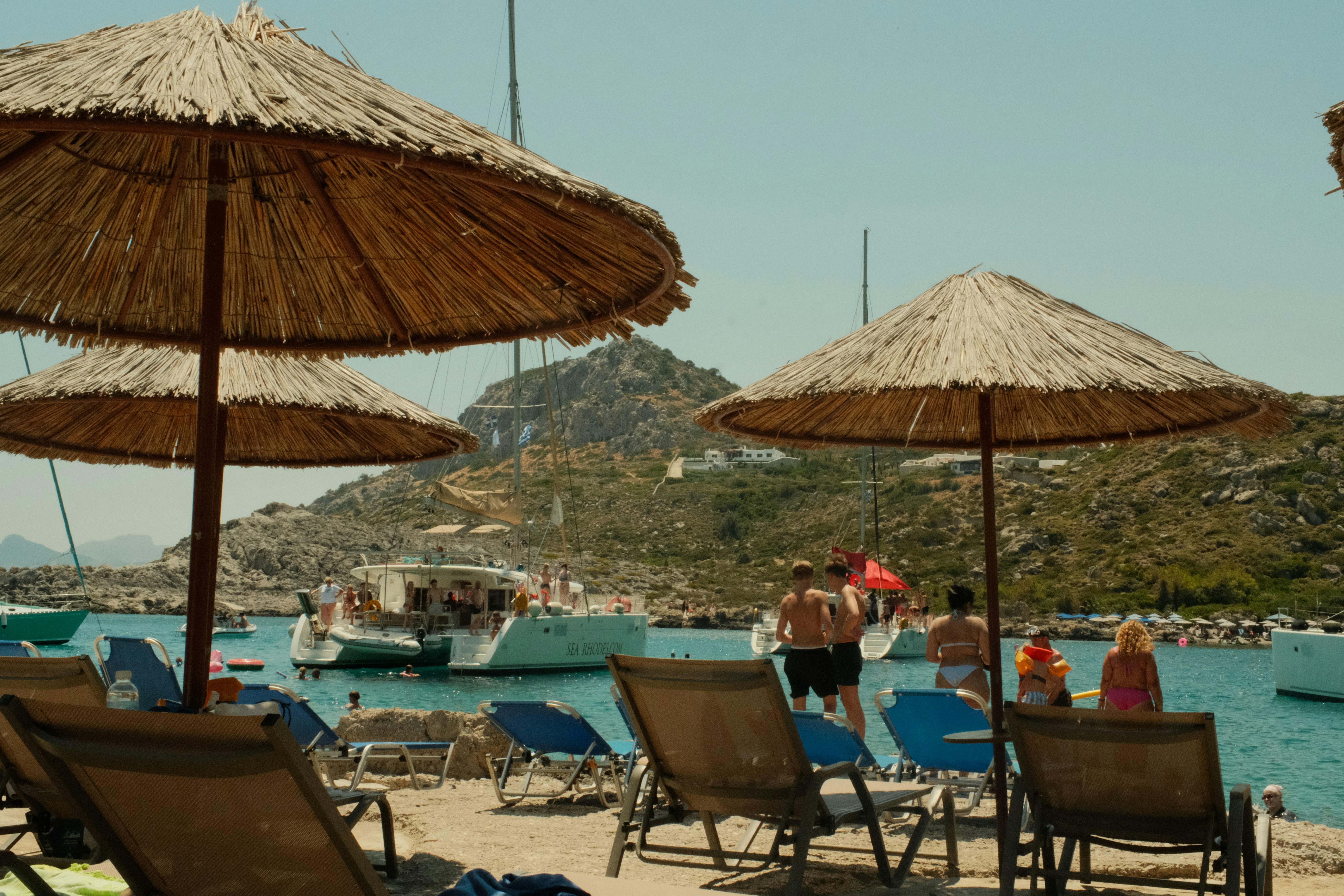 Sunlit Beach Chairs and Straw Umbrellas Framing a Turquoise Bay
