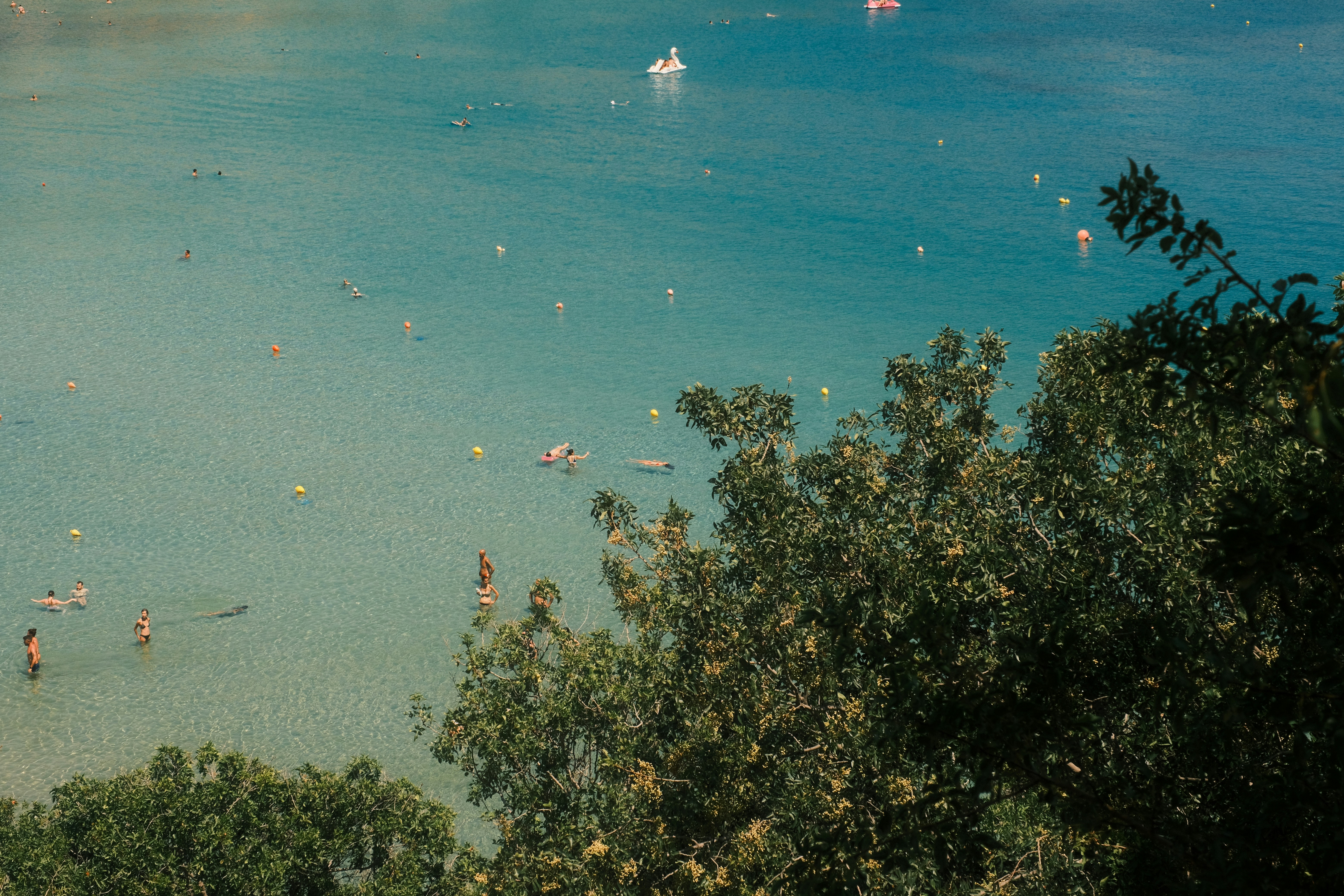 Sunlit Aegean: Distant Beachgoers Beyond the Canopy