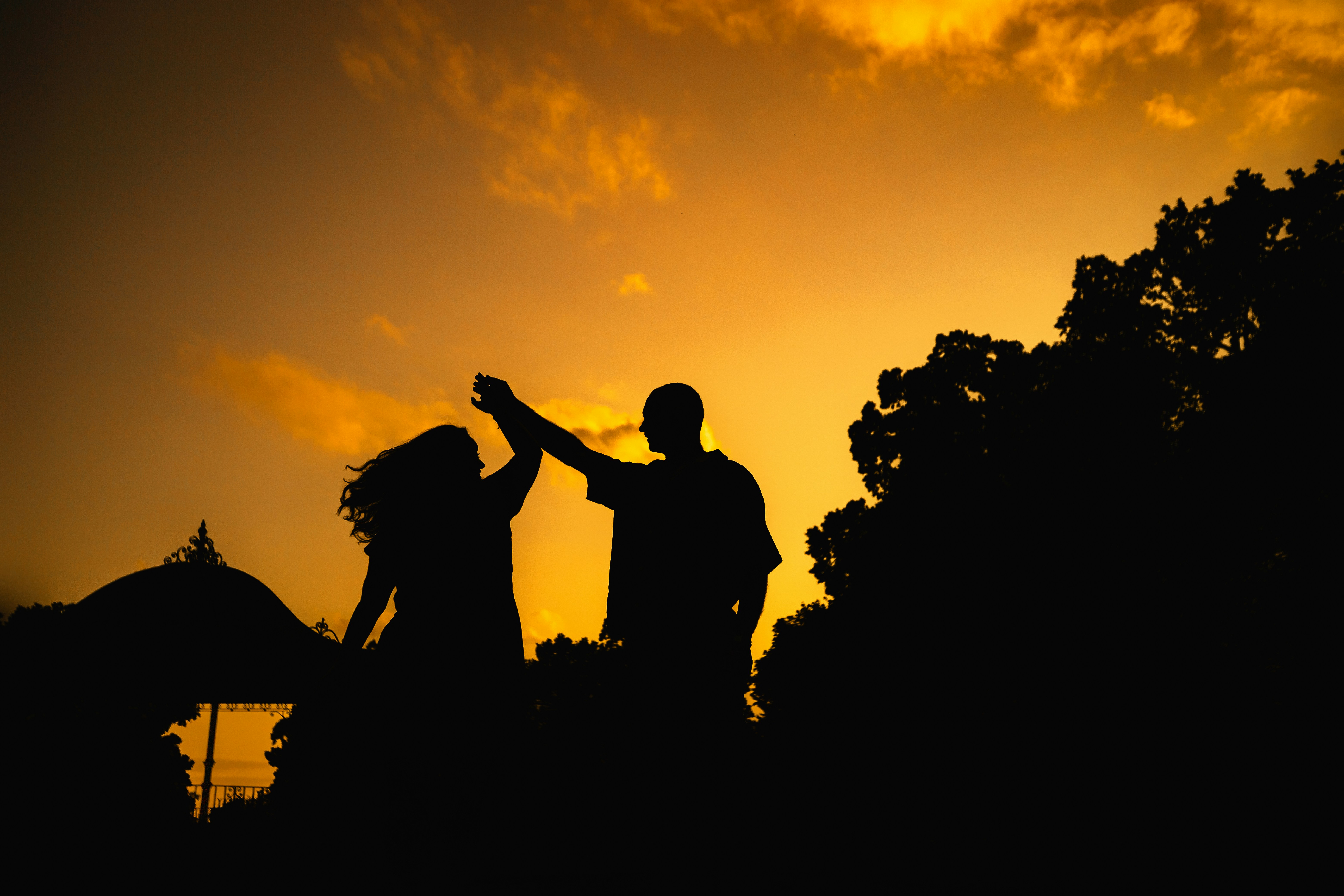 Silhouette of Dancing Couple Against a Golden Sundown