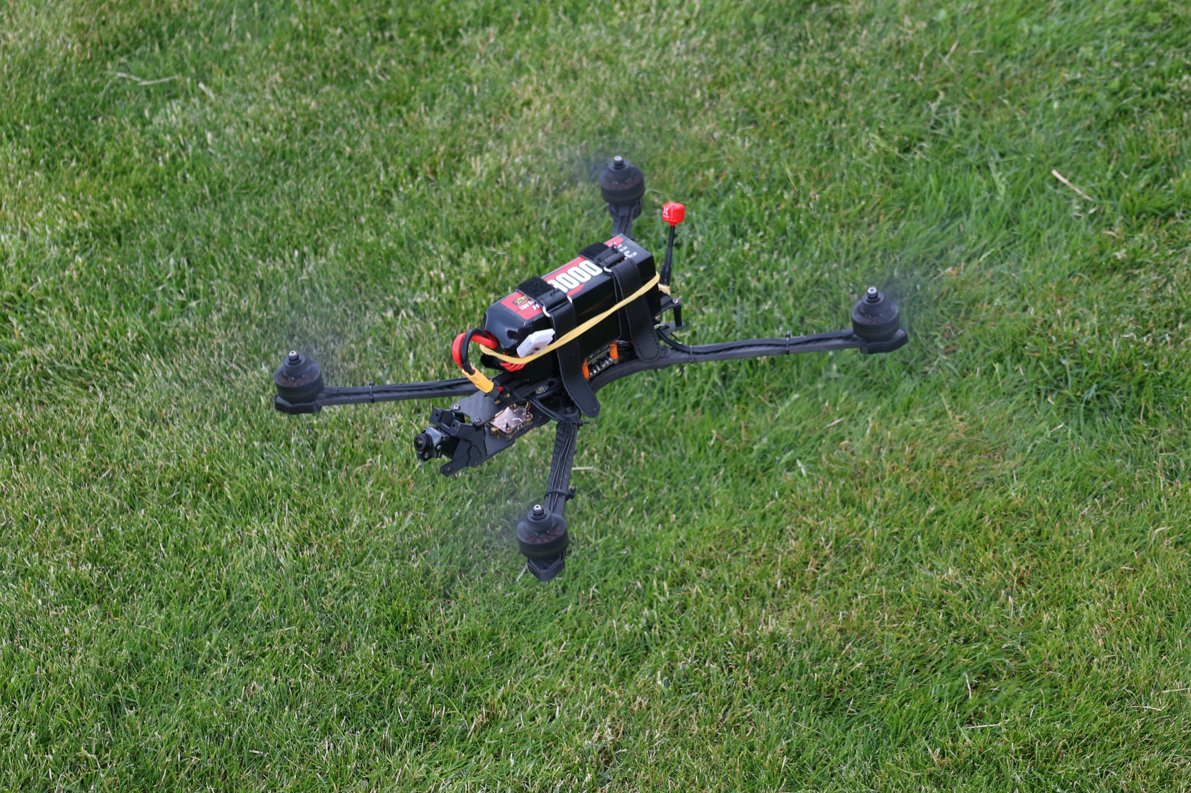 Compact Quadcopter Hover: Aerial drifter above emerald turf