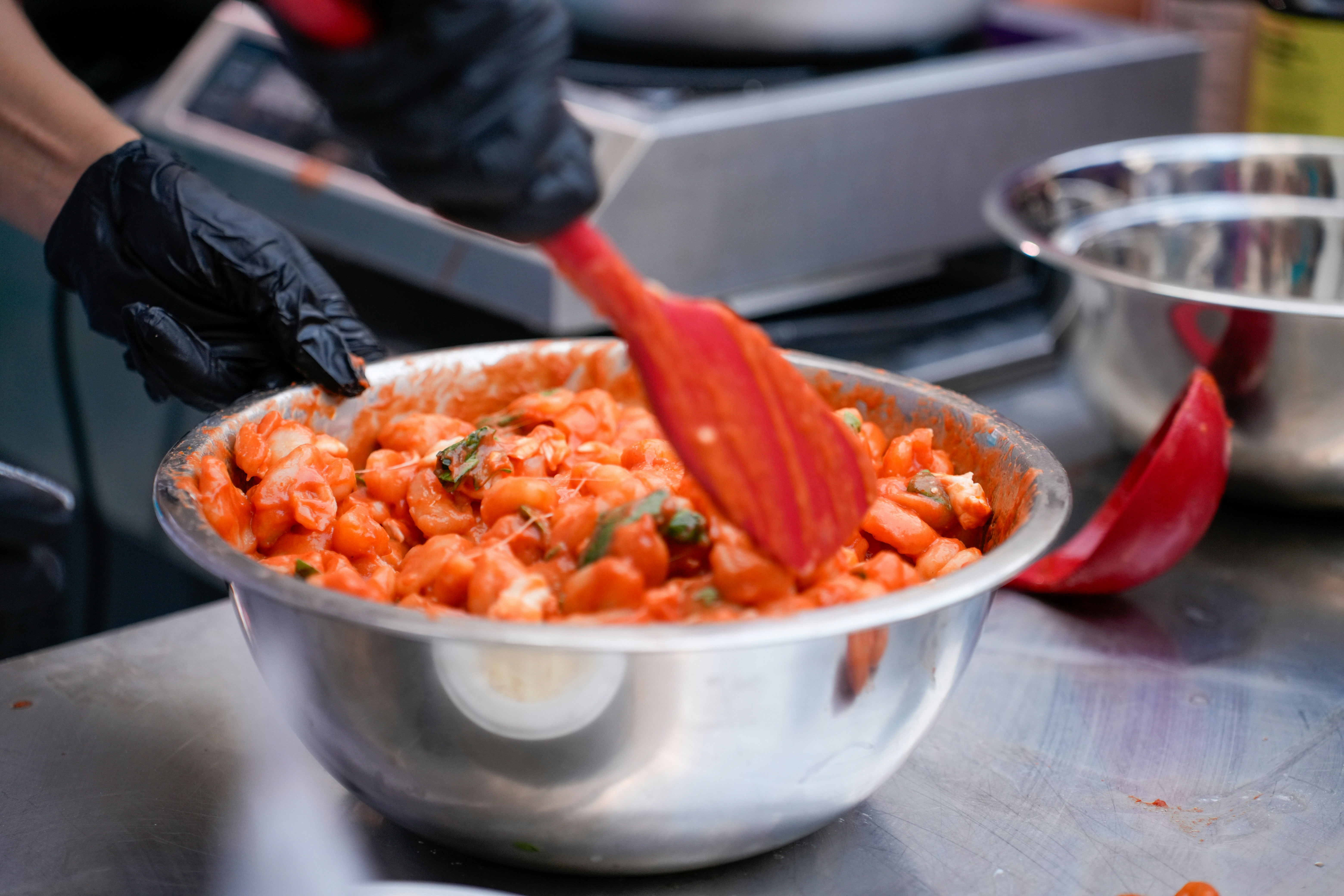 Spatula in Motion: Tossing Spiced Chicken in a Stainless Bowl