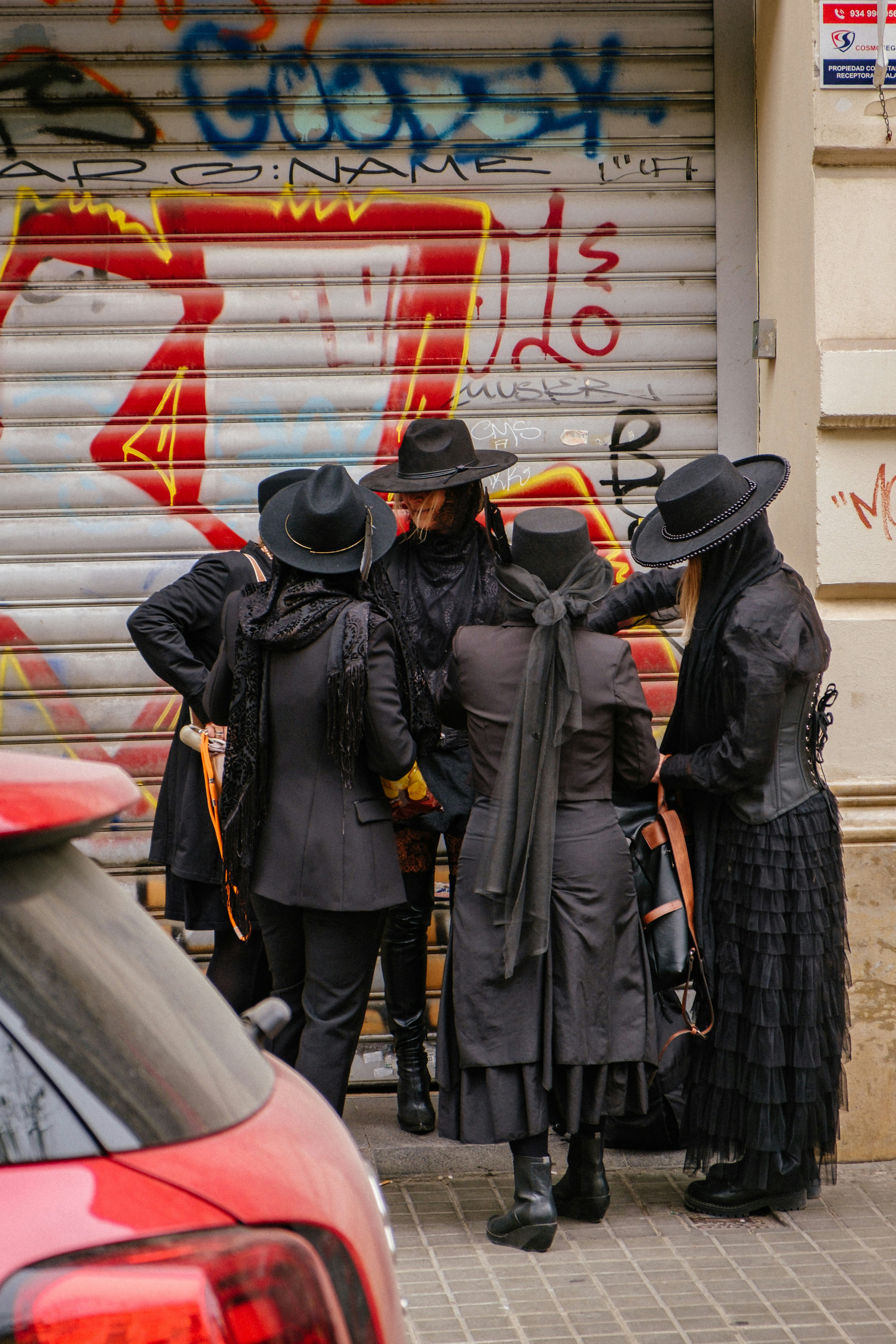 Mysterious Cohort in Black: A Circle of Hats against Graffiti Walls