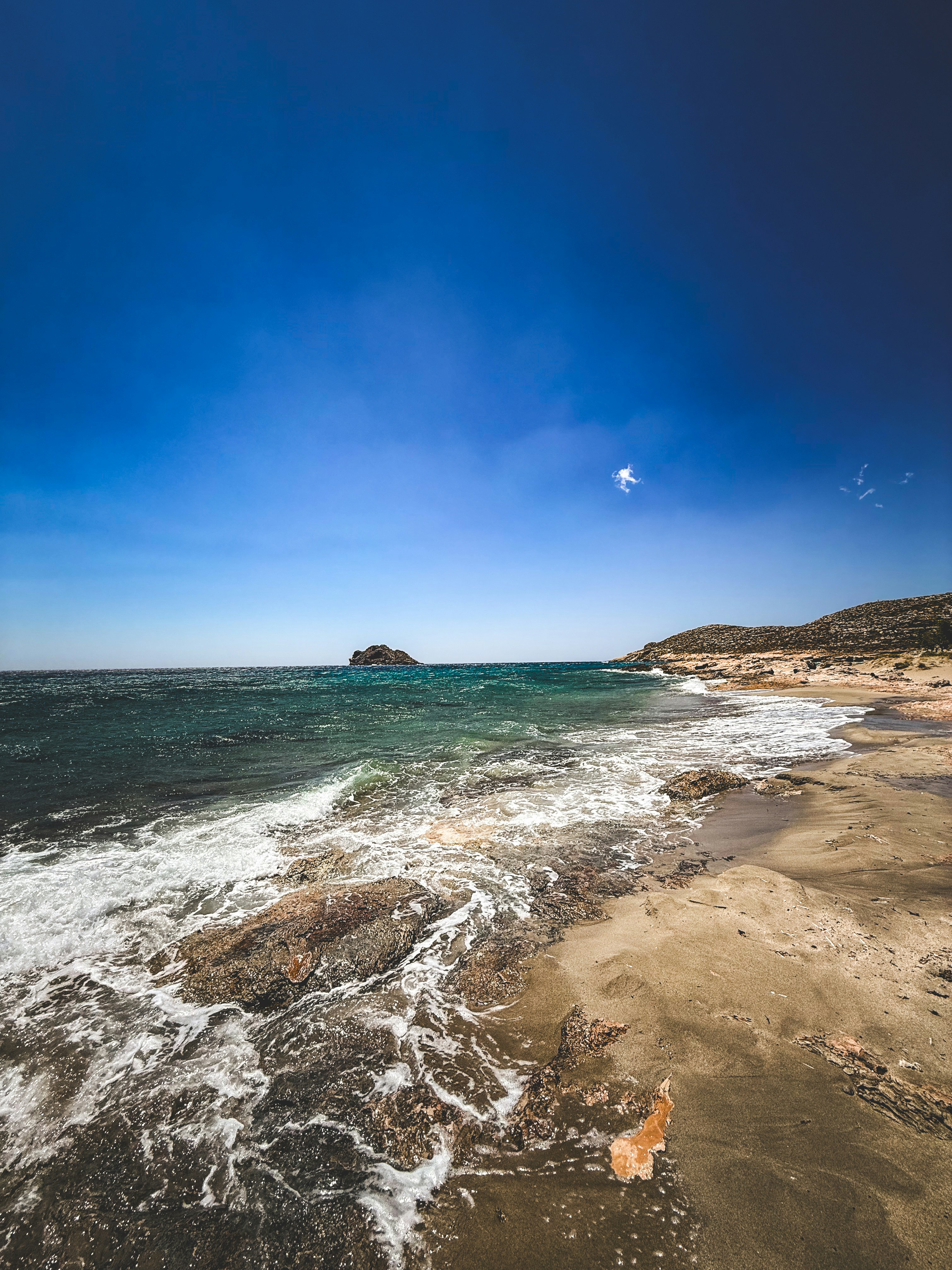 Coastal Horizon: A rocky shoreline under a wide blue sky