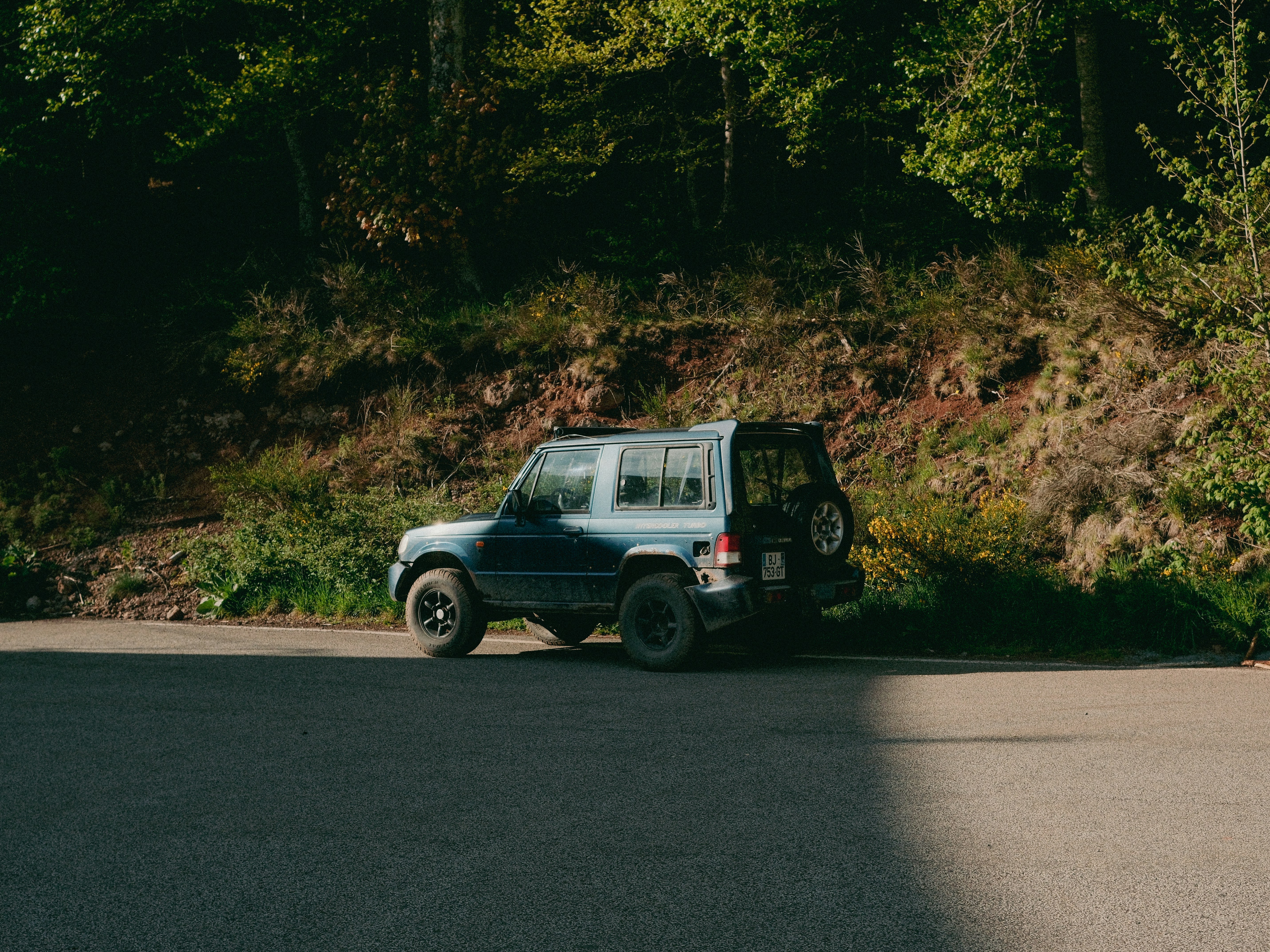 Midday Sunlit Jeep Resting at the Edge of the Trail