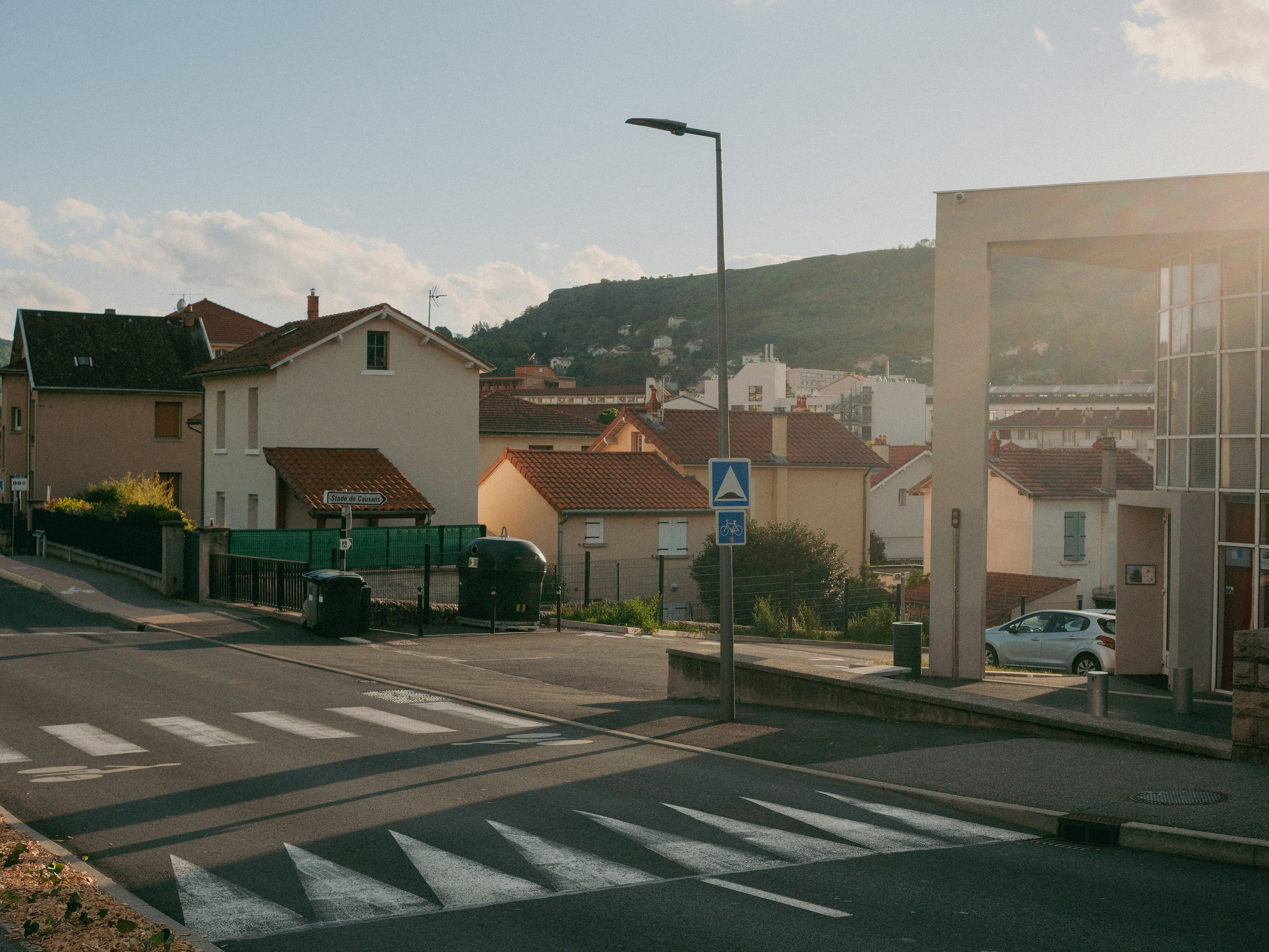 Sunlit Street Crossing Toward a Quiet Town