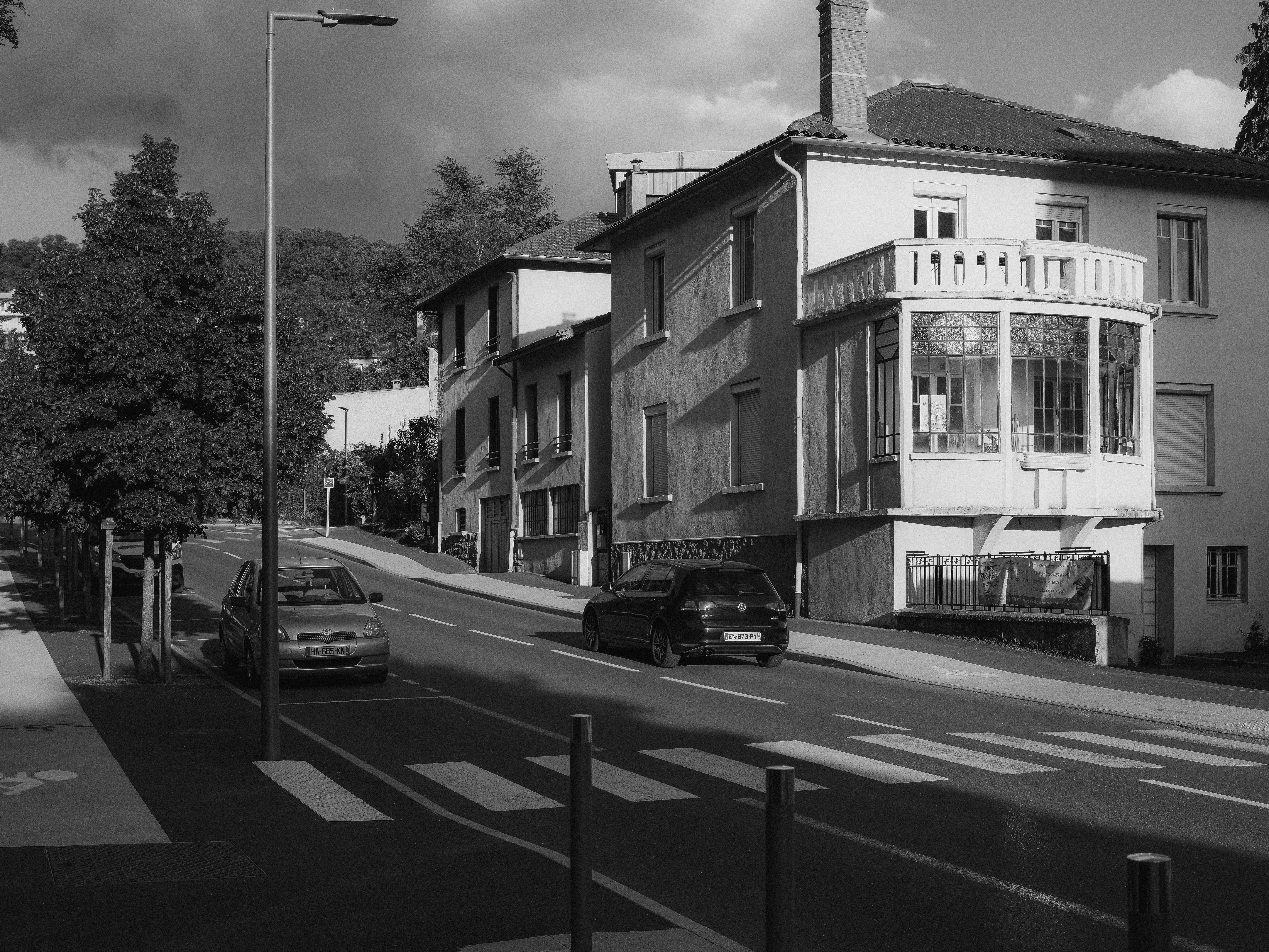 Monochrome Street Ascent: A Quiet Urban Slope with Bend of Cars