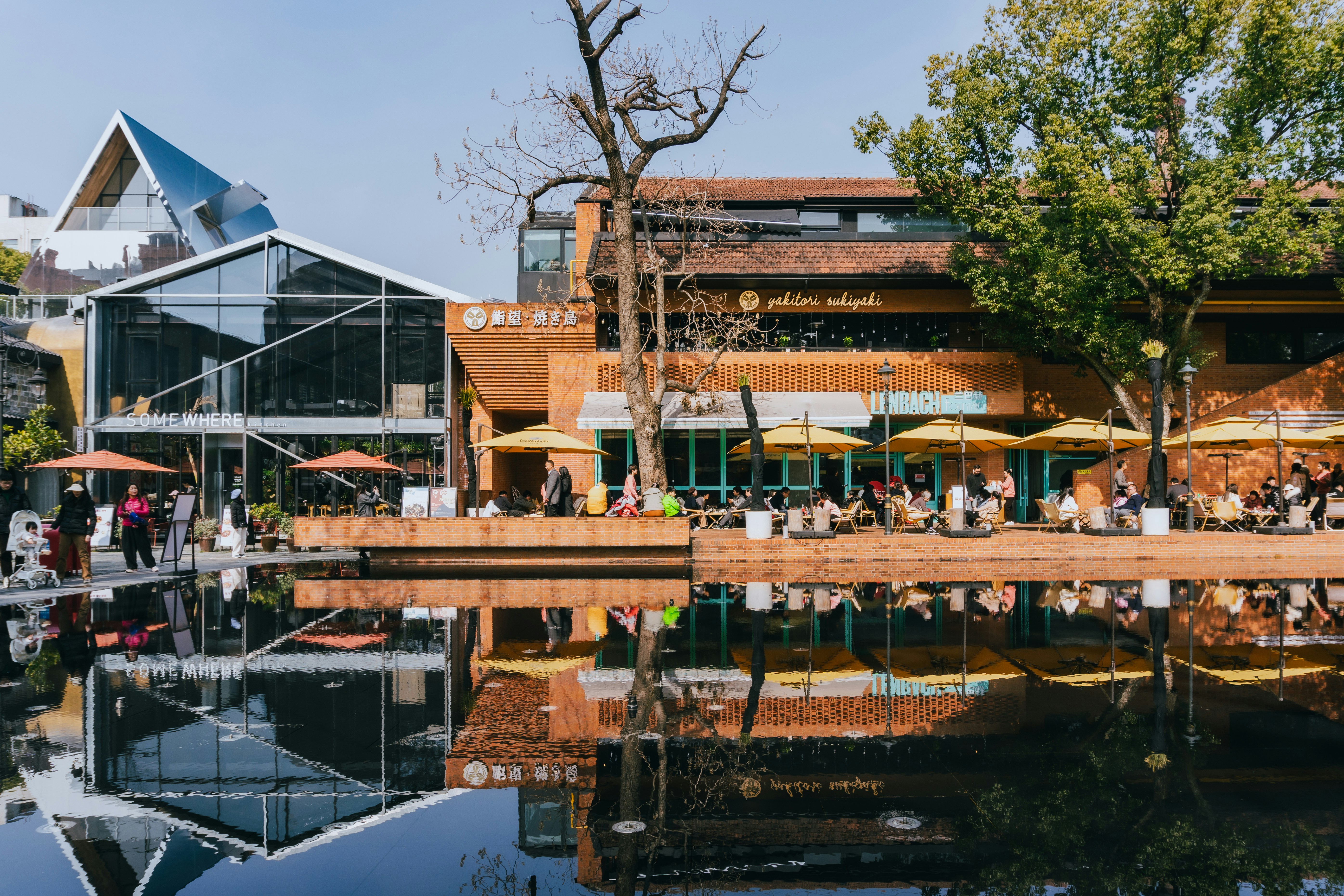Reflective waterfront café facade mirroring a lively street scene