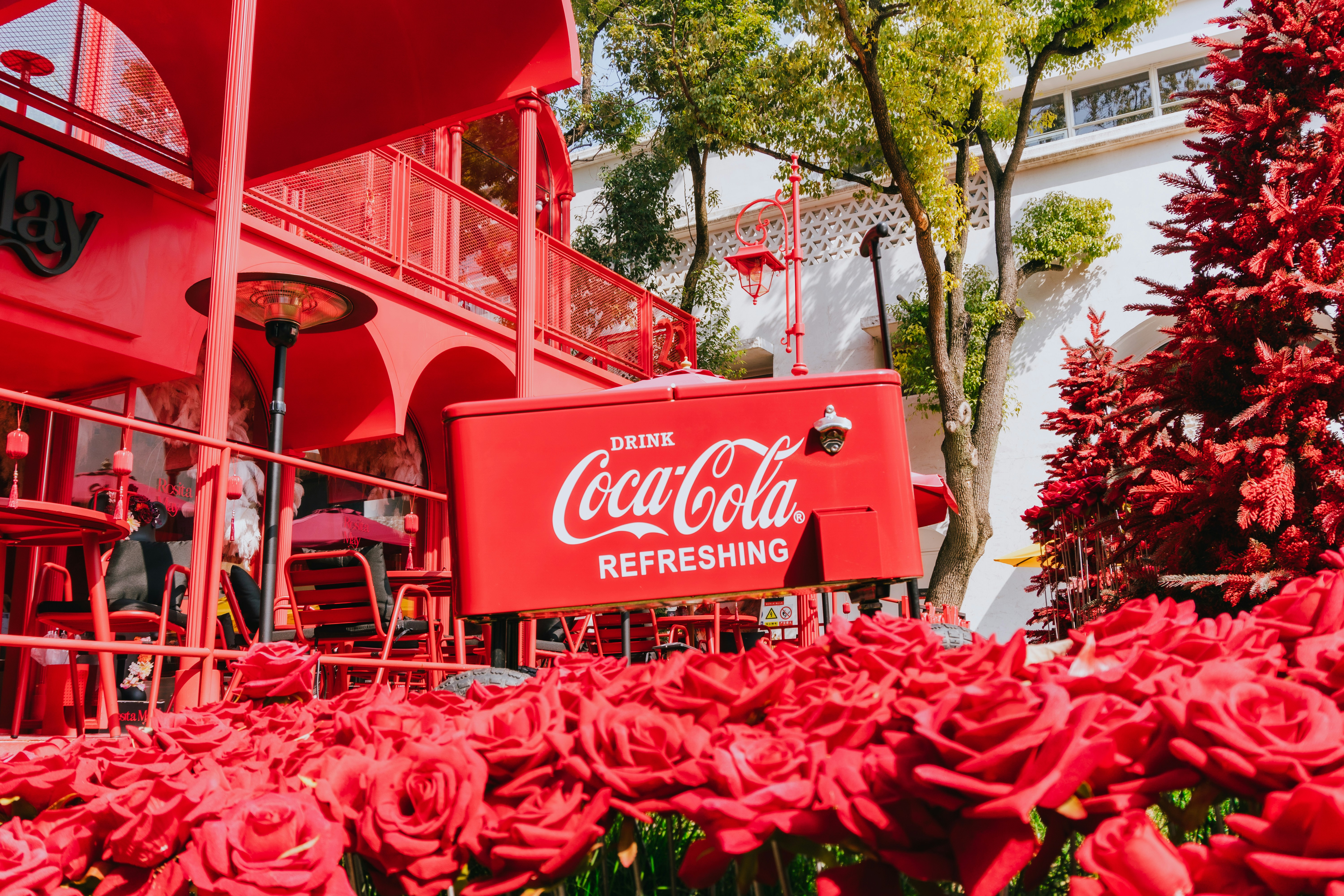 Red Oasis: Coca-Cola Terrace Framing a Blooming Foreground