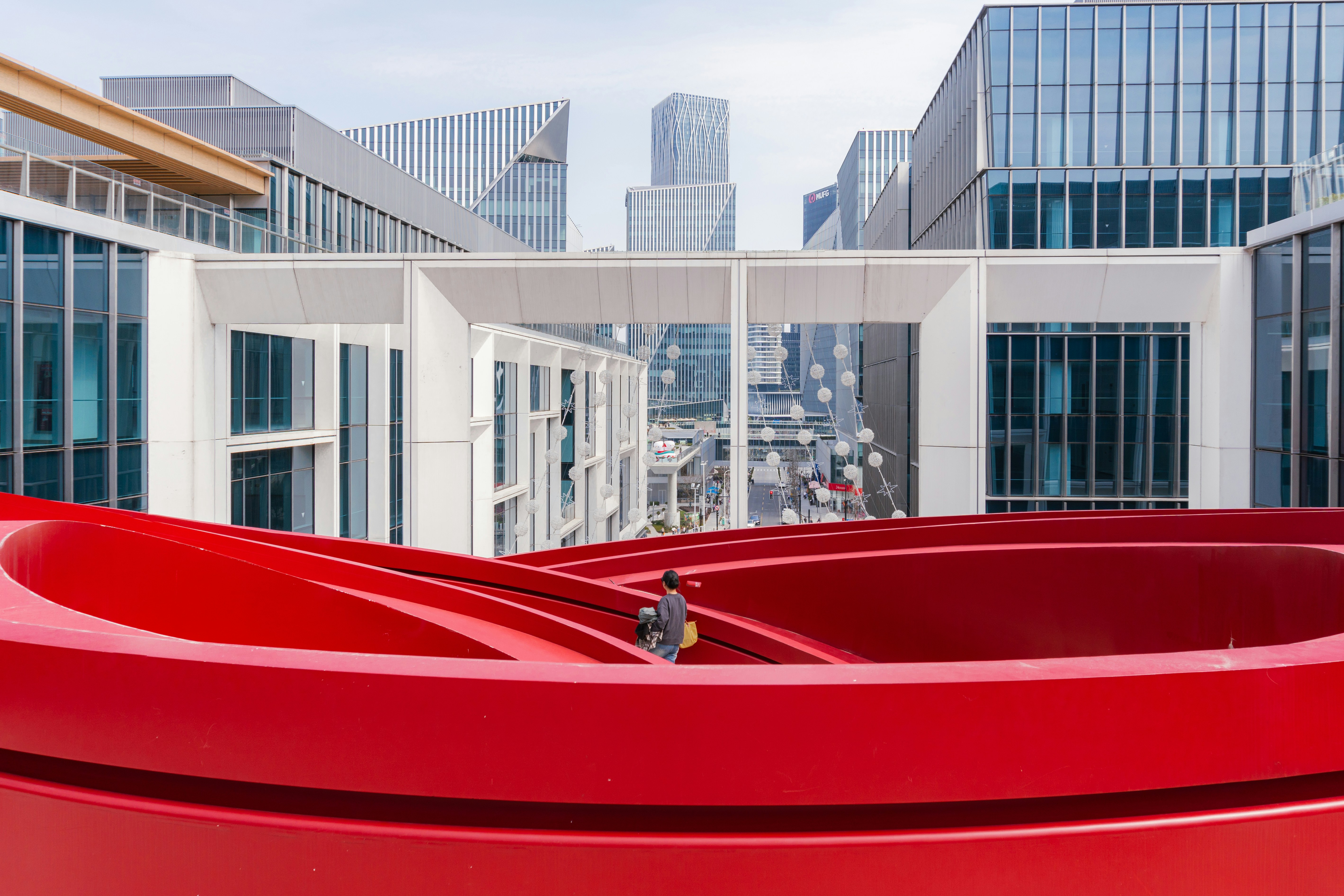 Red Circular Terrace Overlooking a Modern Cityscape