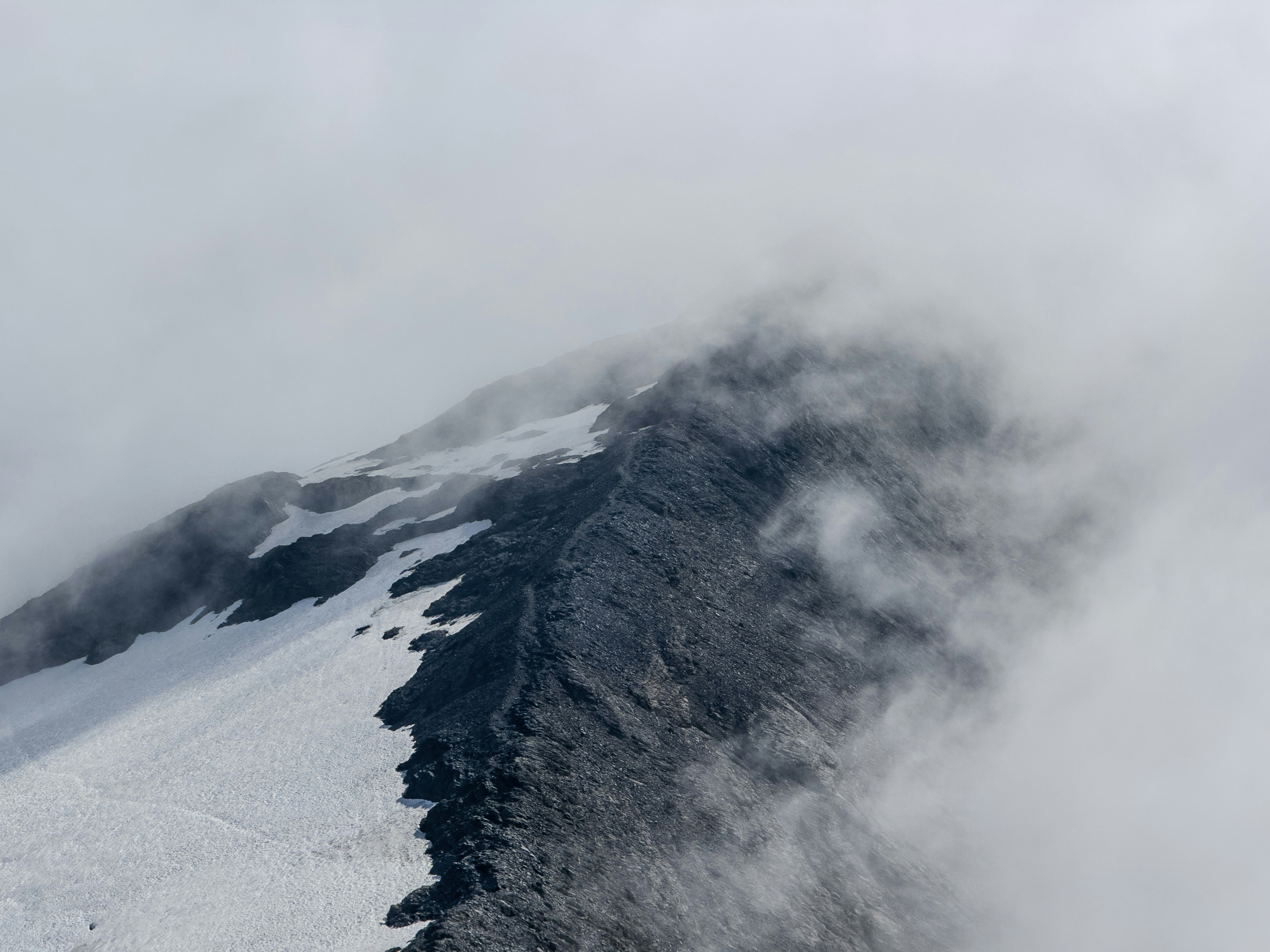 Mist-Shrouded Crest: Snow, Rock, and Cloud