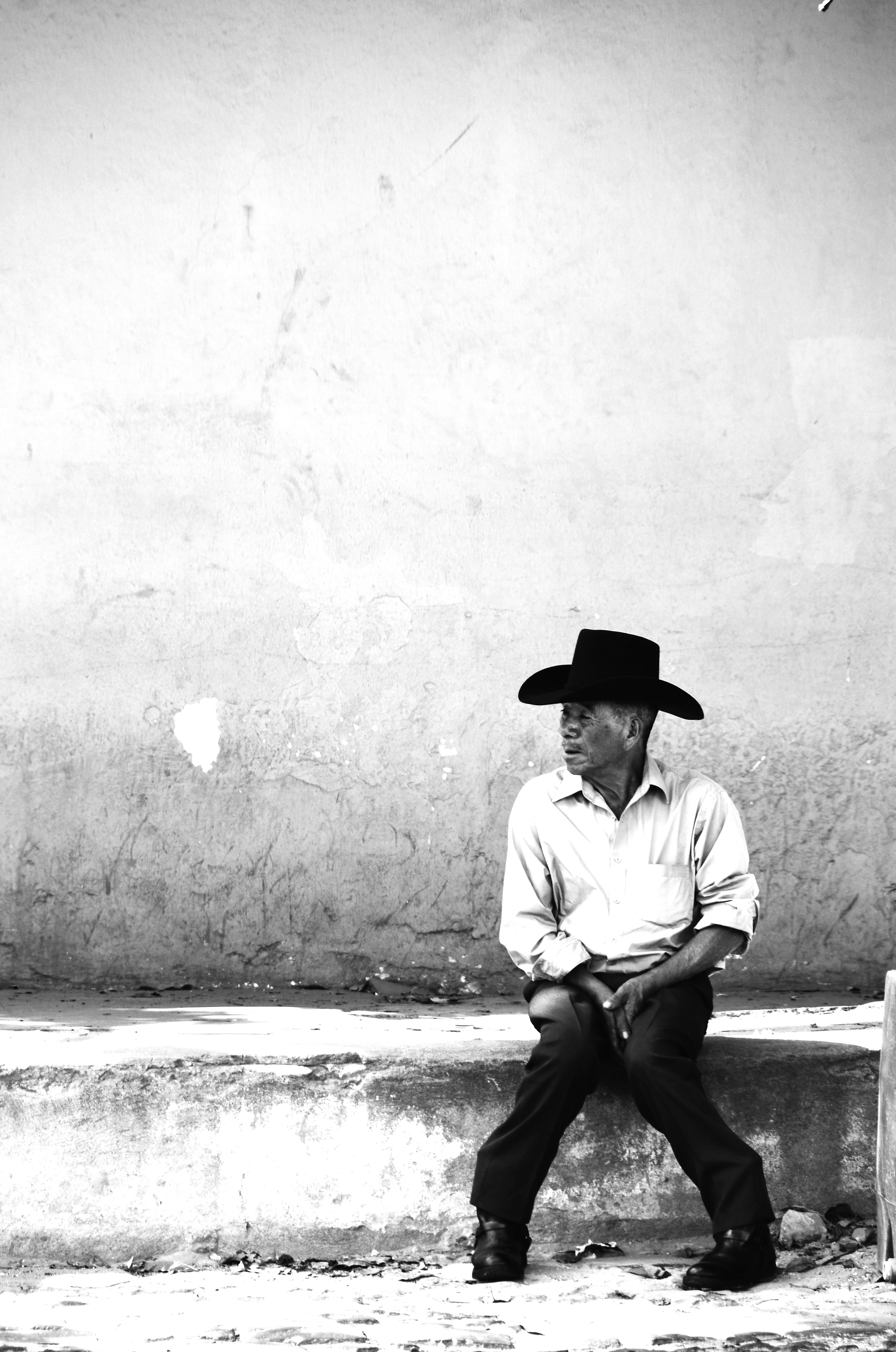 Solitary Witness in the Shade: A Cowboy Seated by the Wall