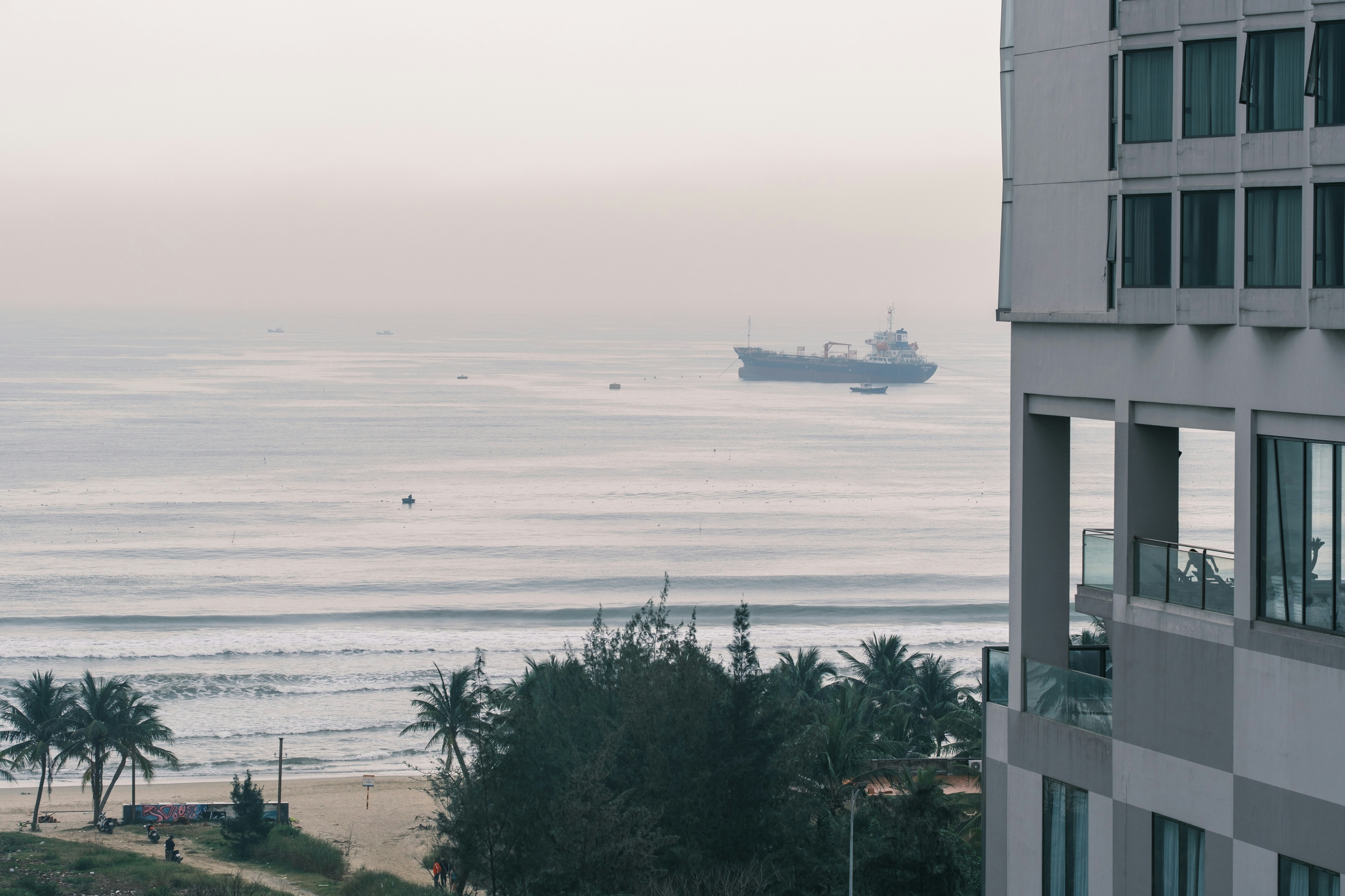 Coastal Edge: A Ship Traverses the Calm Horizon Past a Modern Terrace
