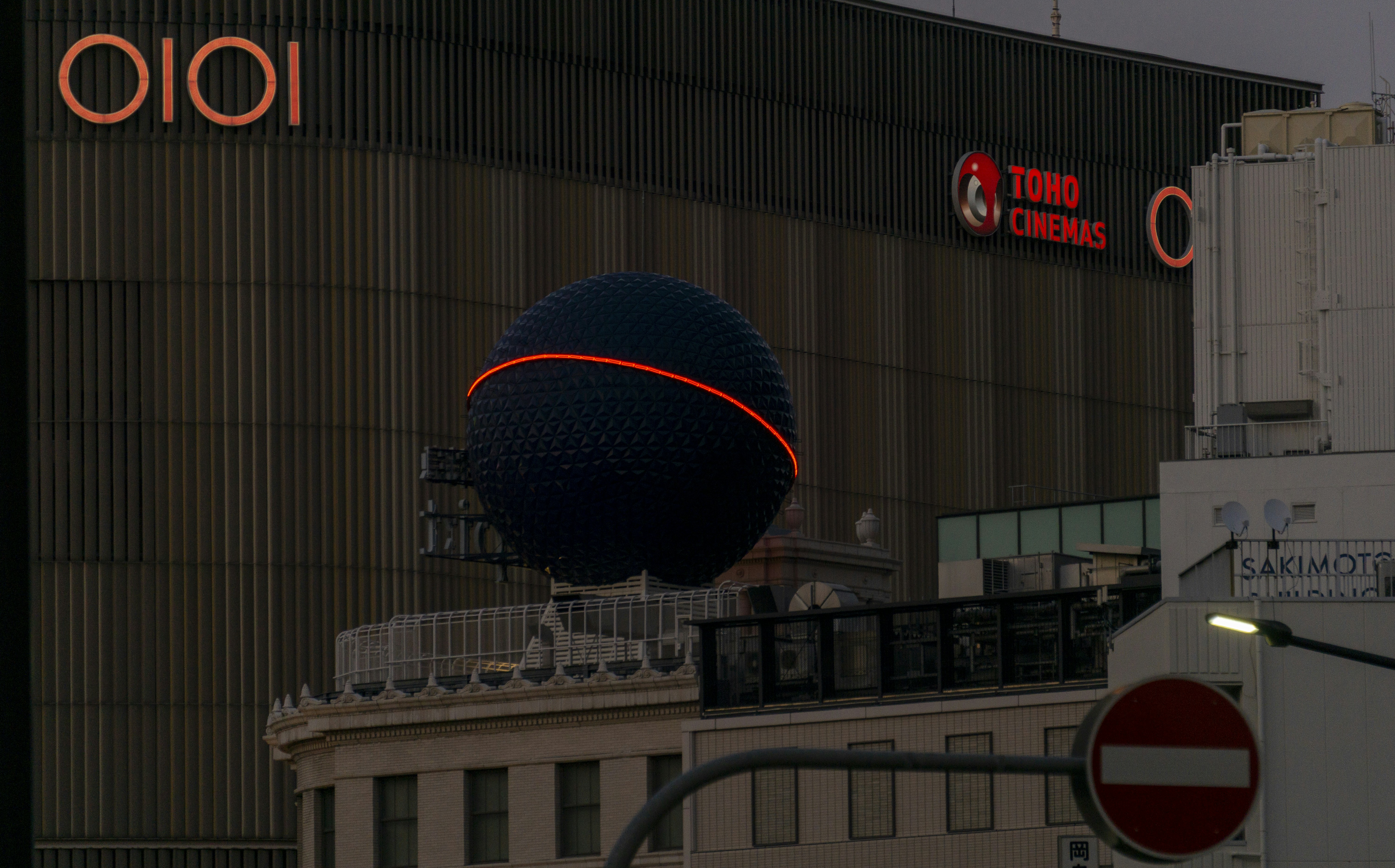 Neon Sphere over Tokyo’s Midnight facade
