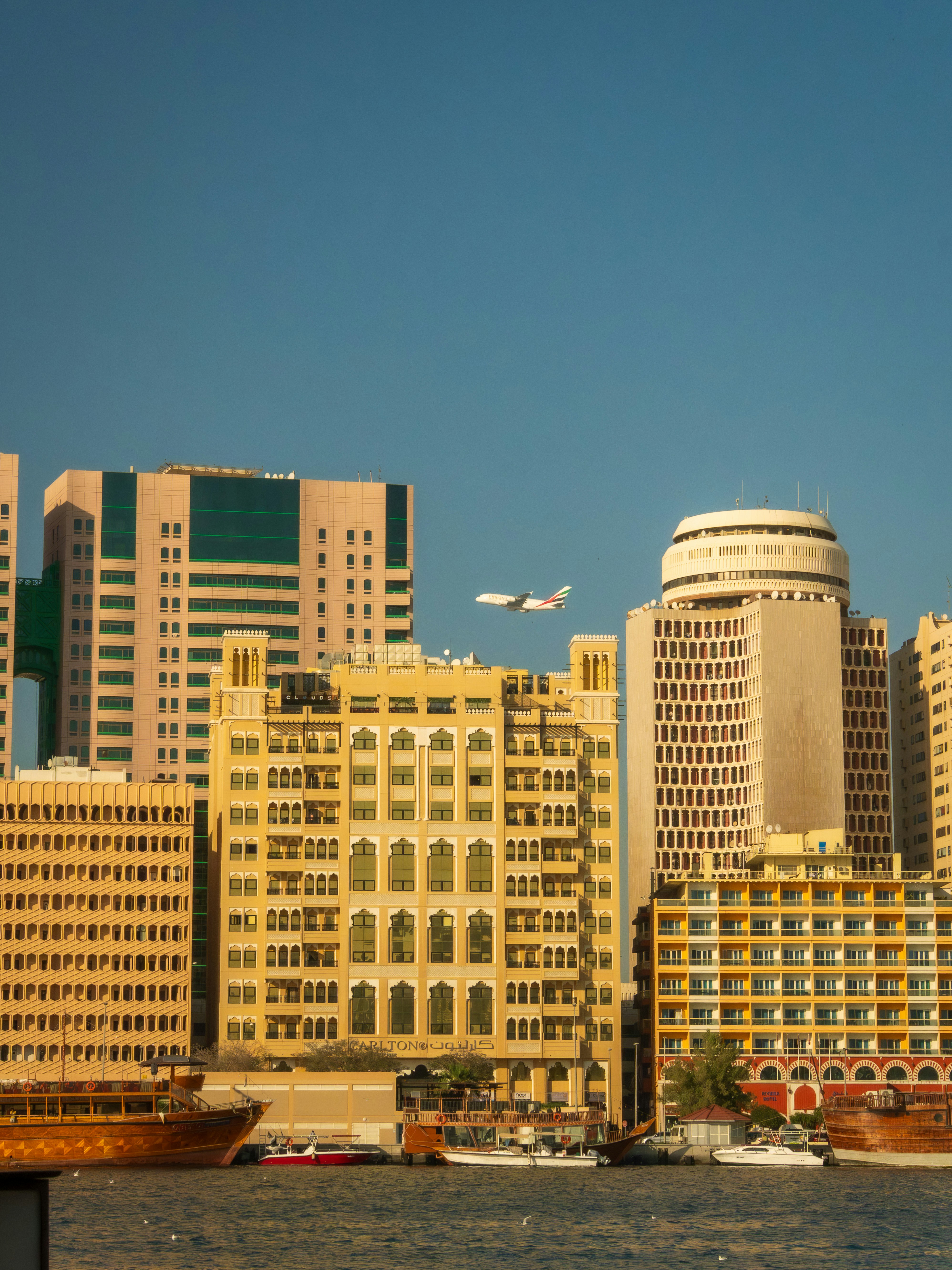 Harborfront Towers Tilt Toward the Sky as Plane Passes