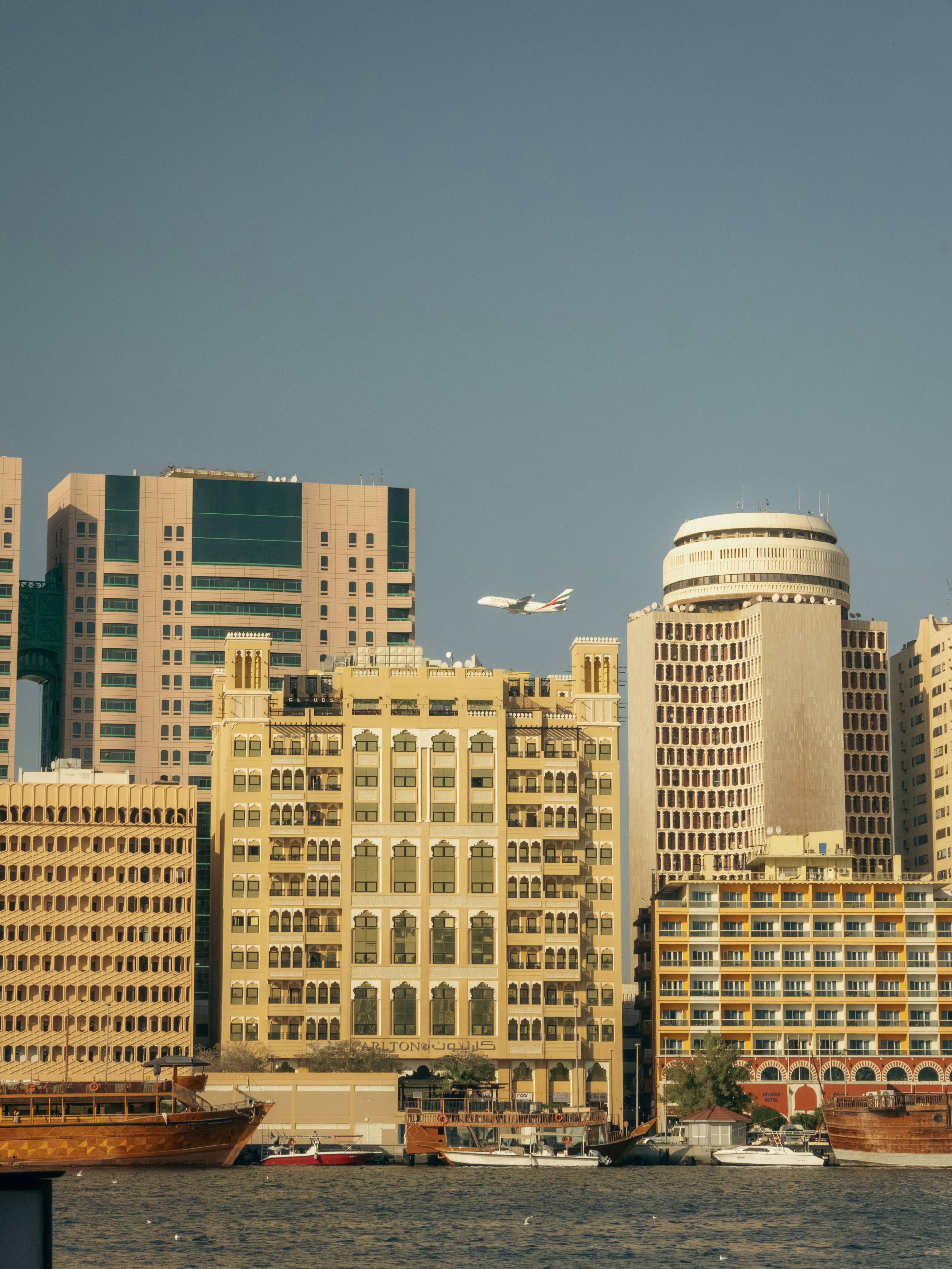 Harbor City Skyline: A Plane Skims the Glassy Blue