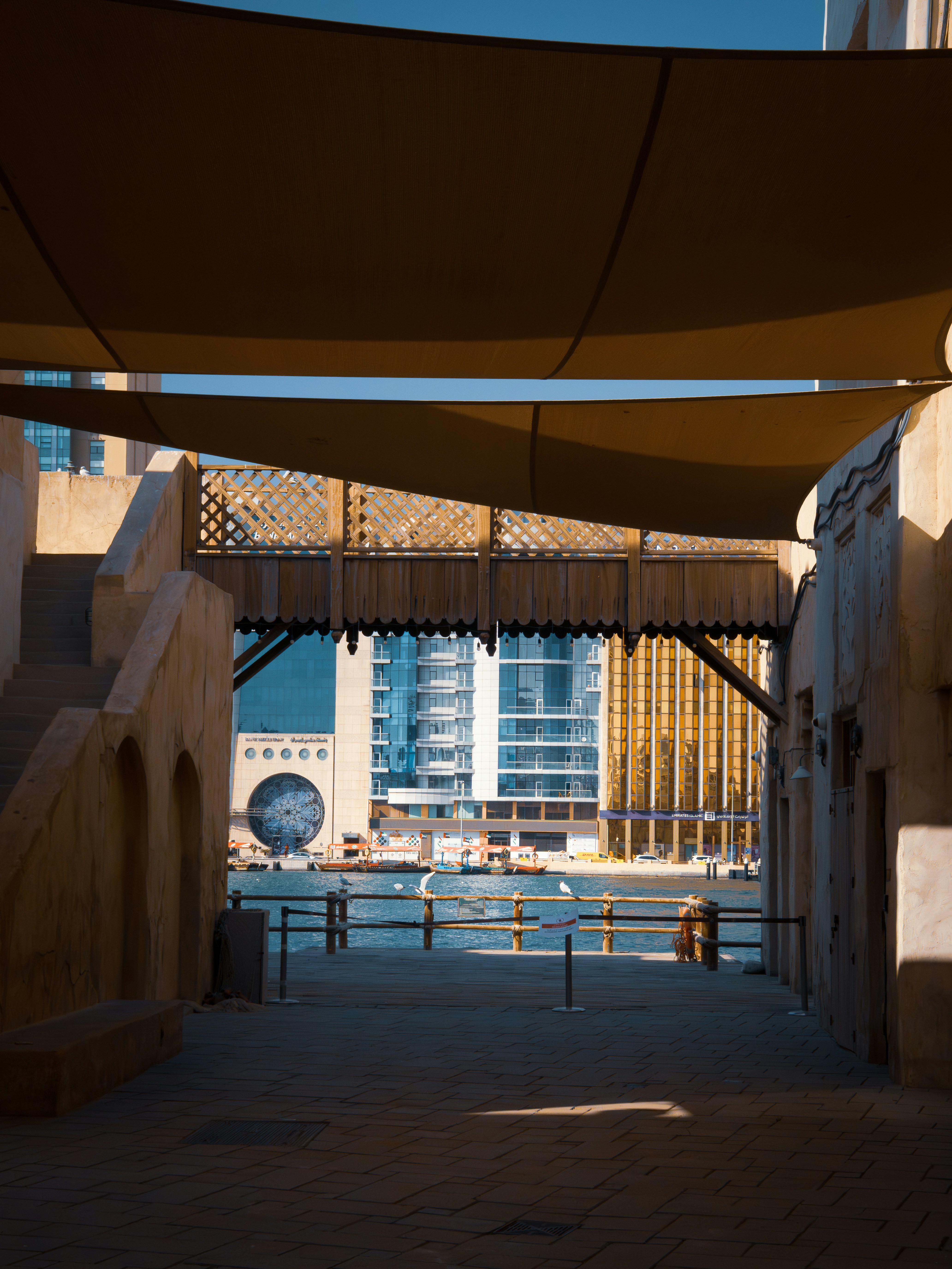 Through the Shade: A Waterfront Passage Framed by Sun and Steel