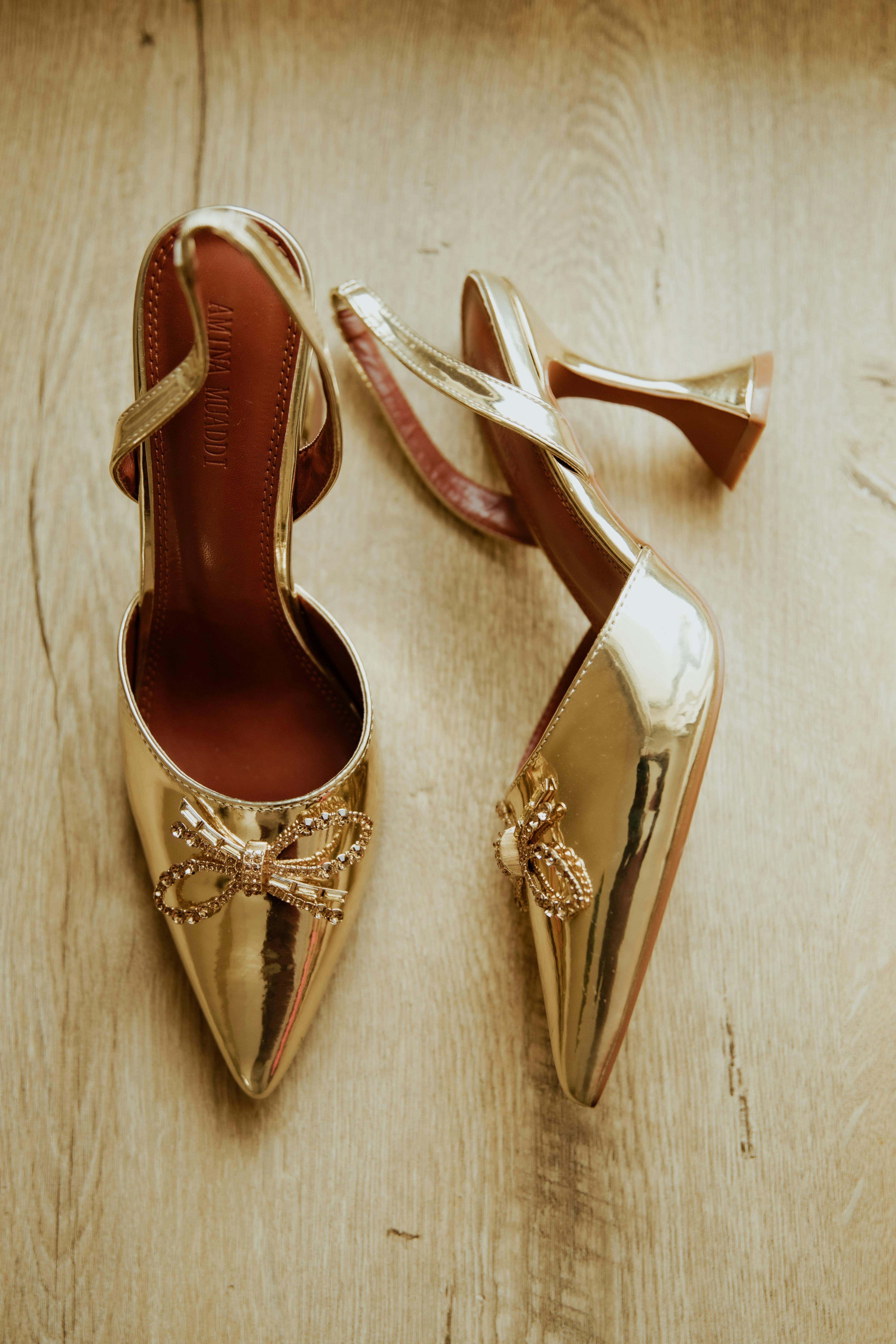 Golden Slippers: A Pair of Metallic Heels Resting on Wood